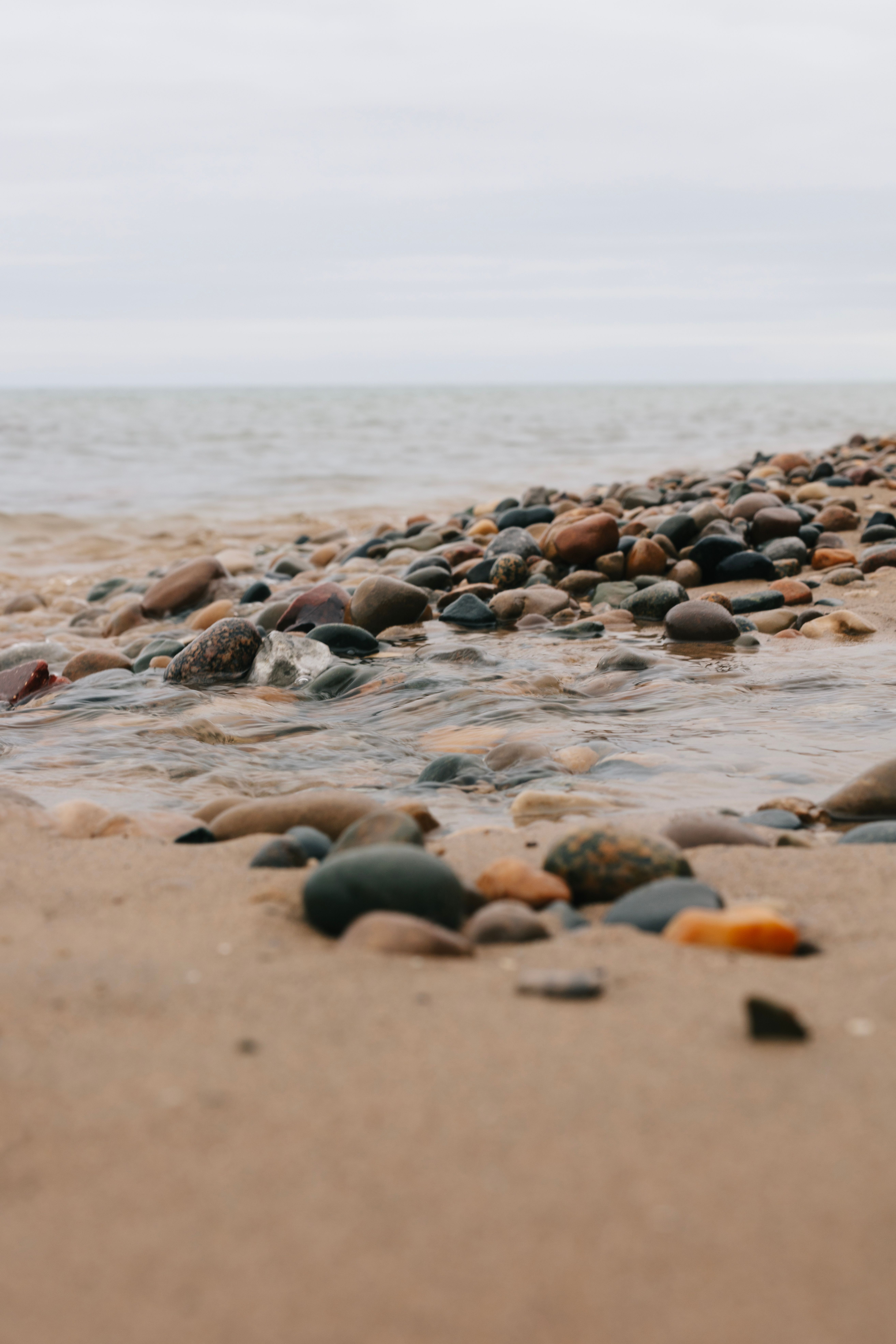 Serene Pebble Beach Shoreline Scene in Winter · Free Stock Photo