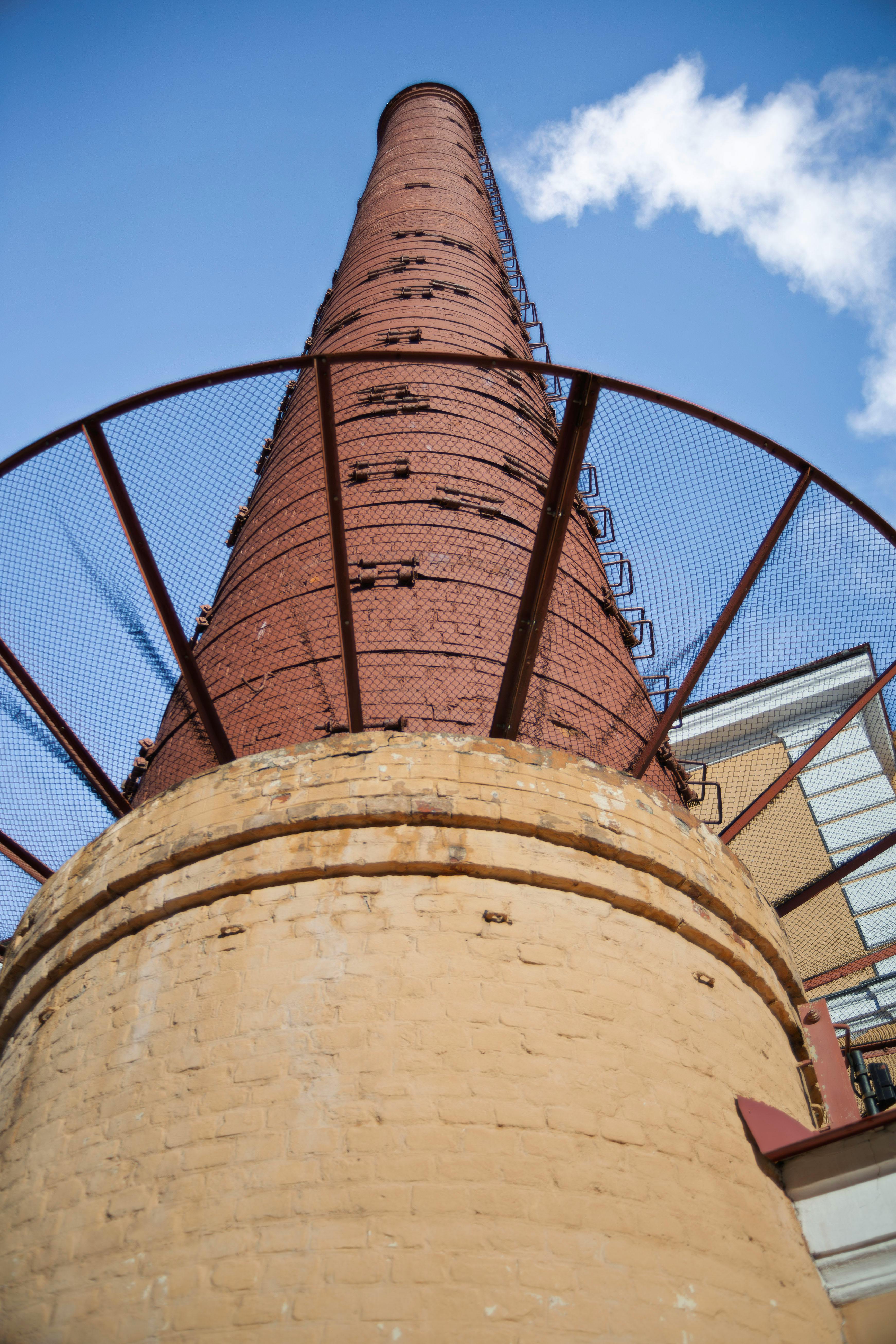Industrial Brick Chimney Against Blue Sky · Free Stock Photo
