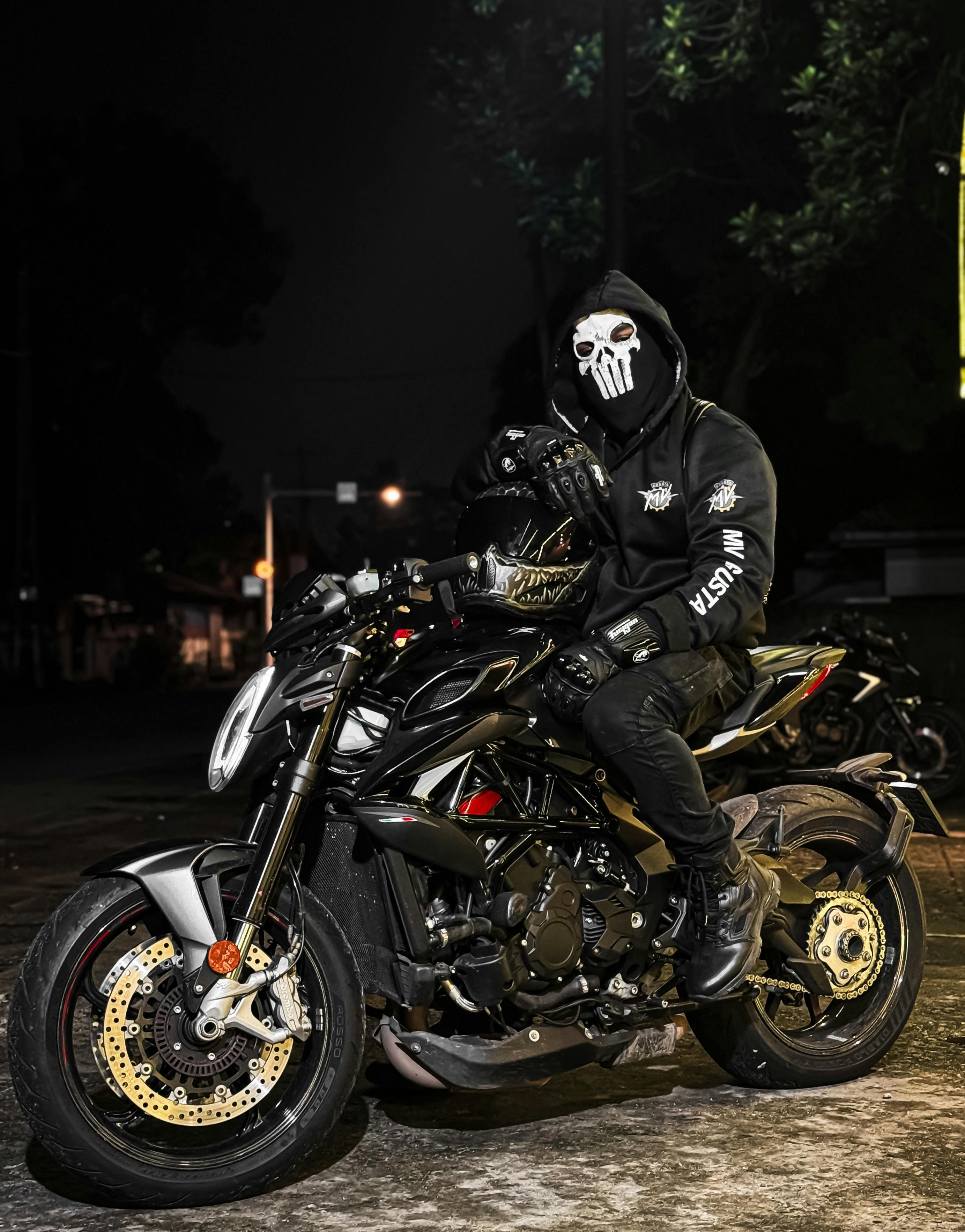 Nighttime Biker in Mask Sitting on Motorcycle · Free Stock Photo