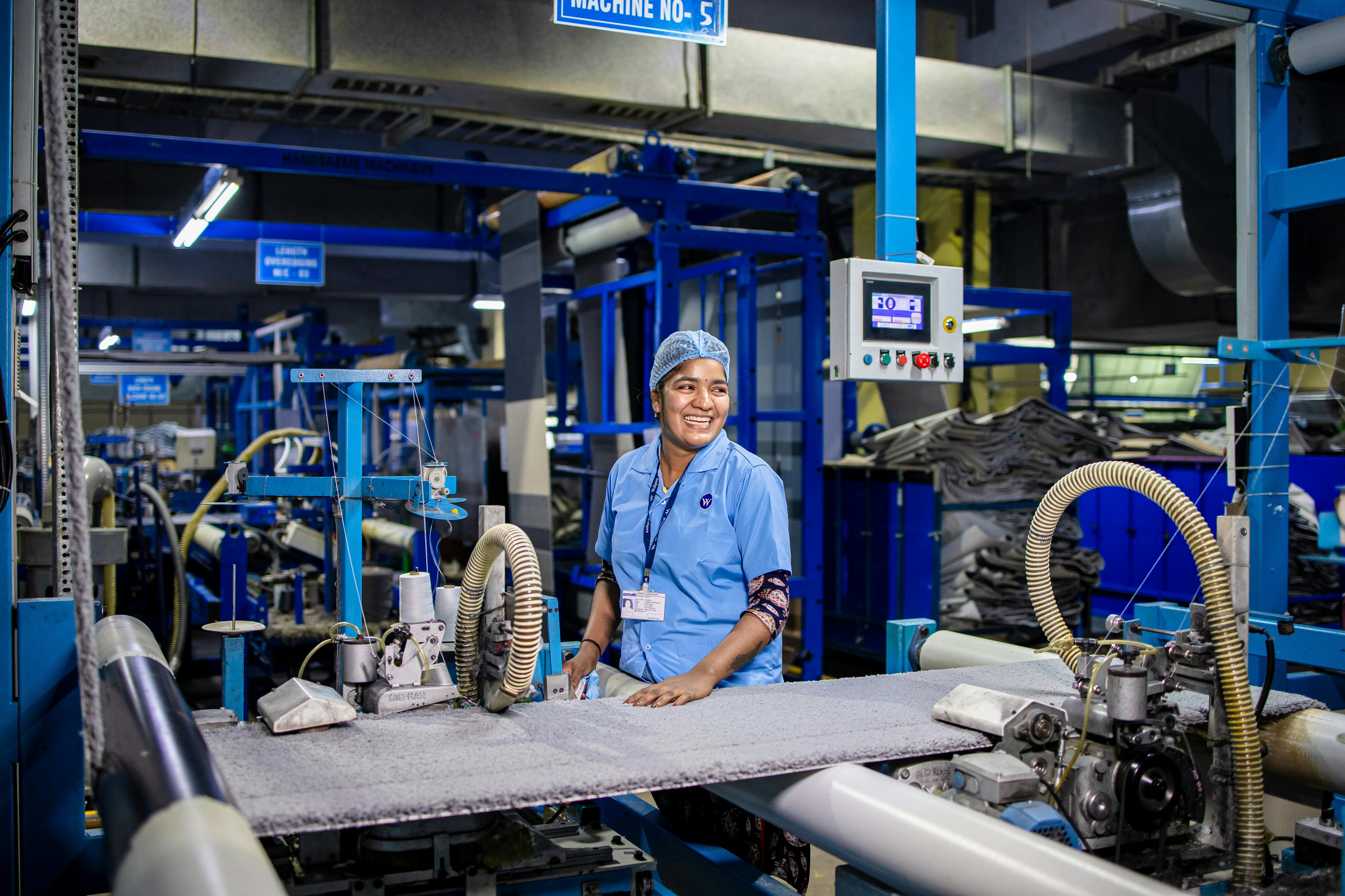Textile Factory Worker Operating Machinery Indoors · Free Stock Photo