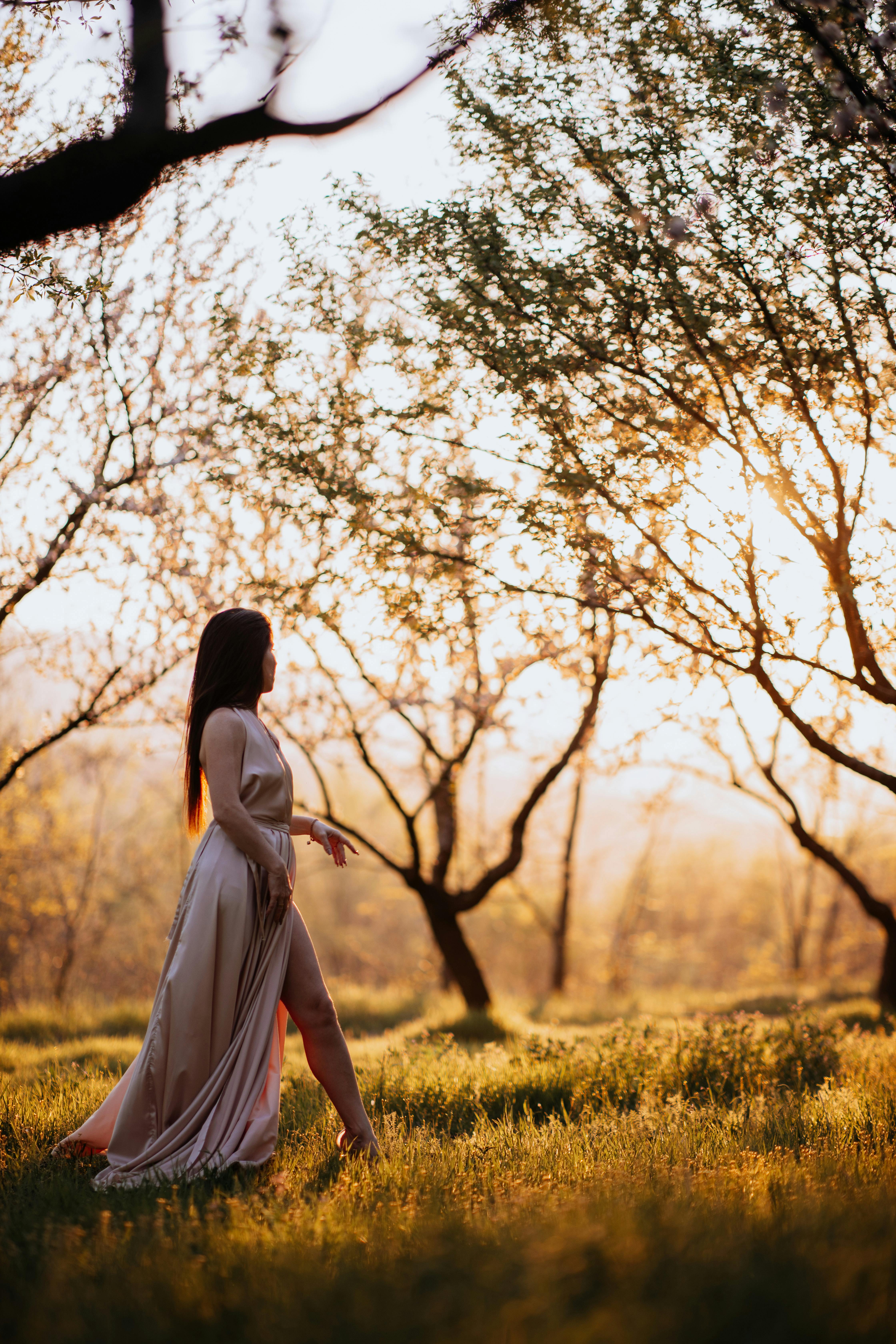 Elegant Woman Walking Through Spring Orchard · Free Stock Photo