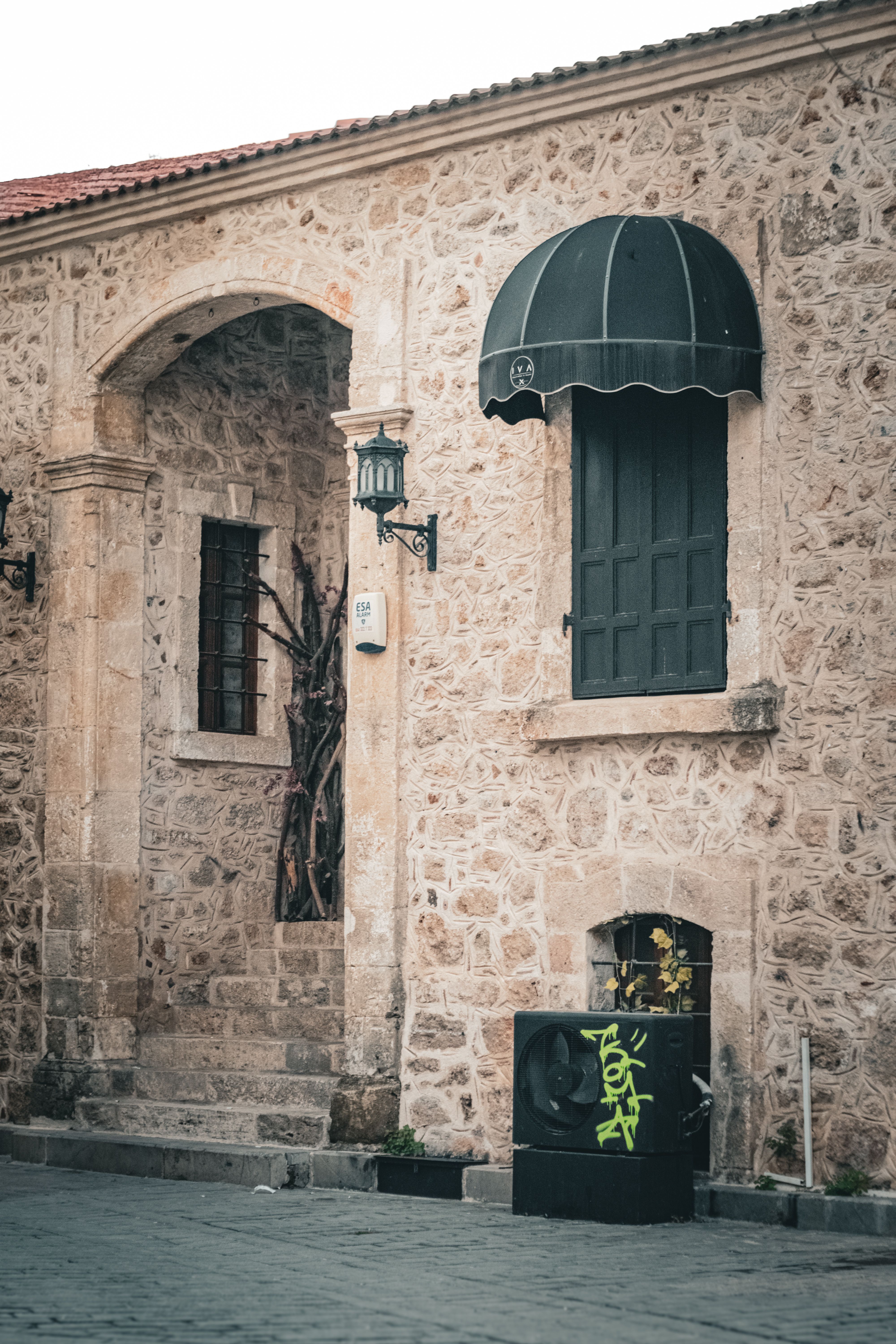Charming Stone Building with Archway and Greenery · Free Stock Photo
