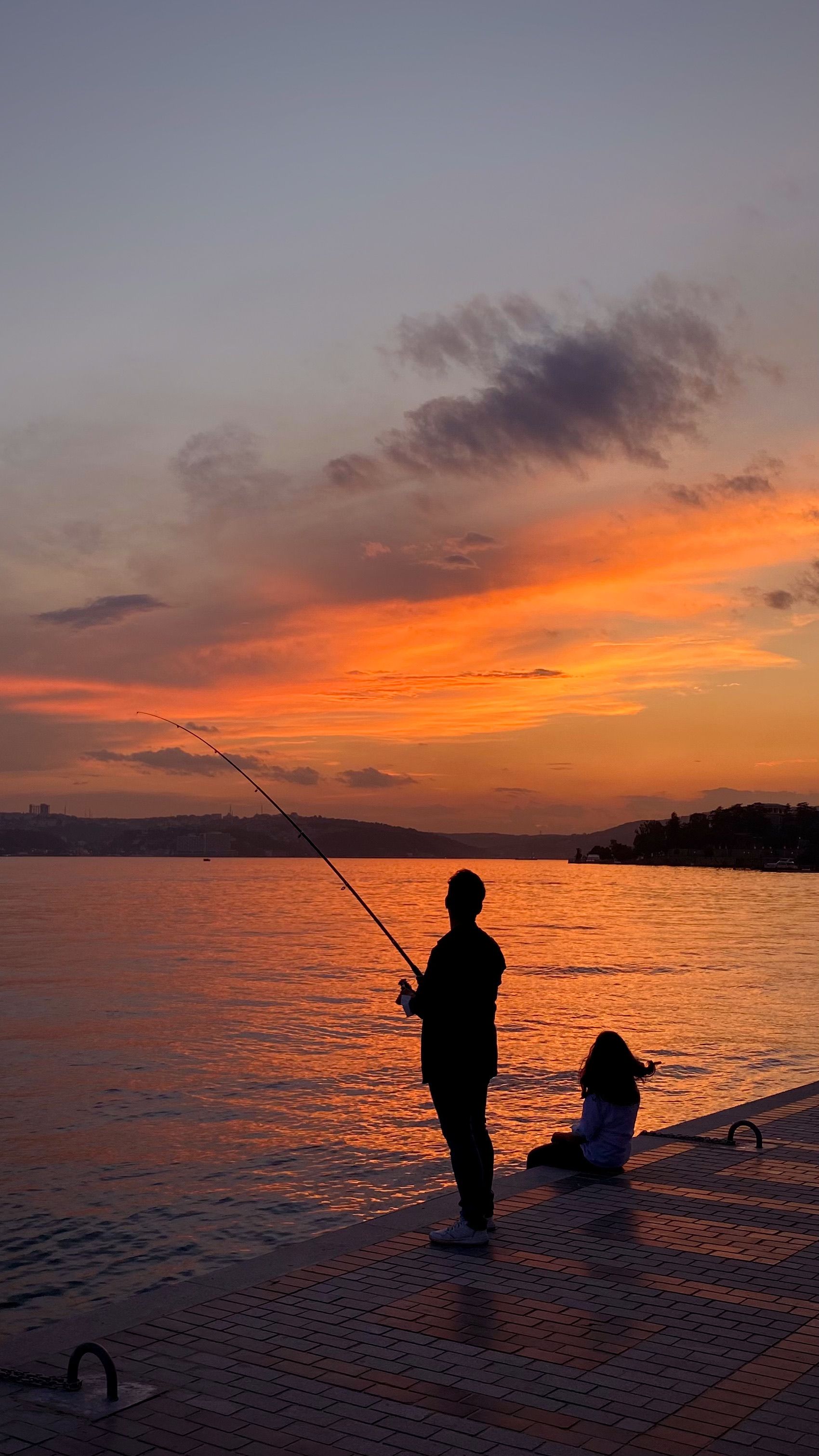 Serene Sunset Fishing by the Waterfront · Free Stock Photo