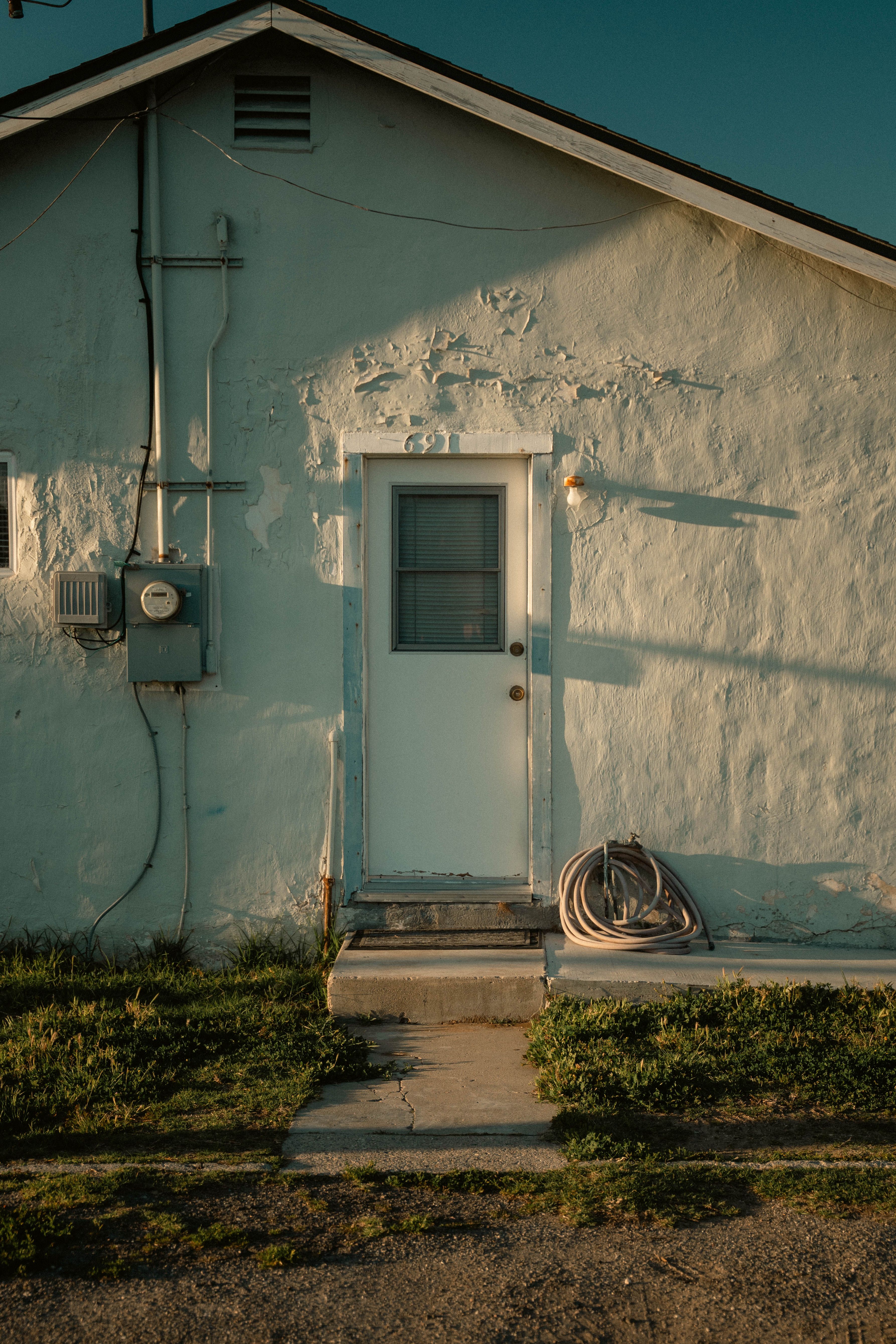 Exterior View of Rustic House with Hose · Free Stock Photo