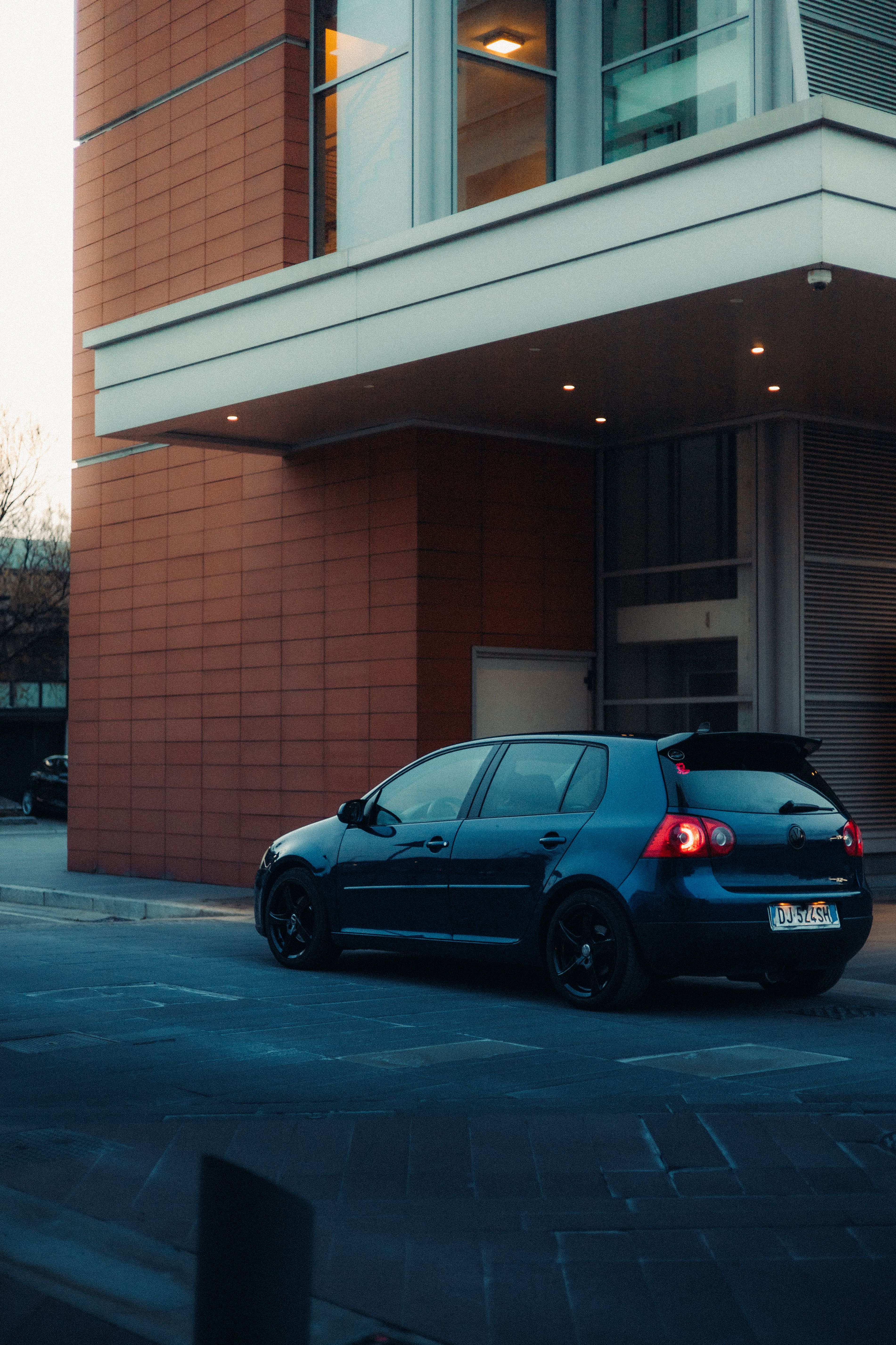 Modern car parked beside urban building exterior · Free Stock Photo