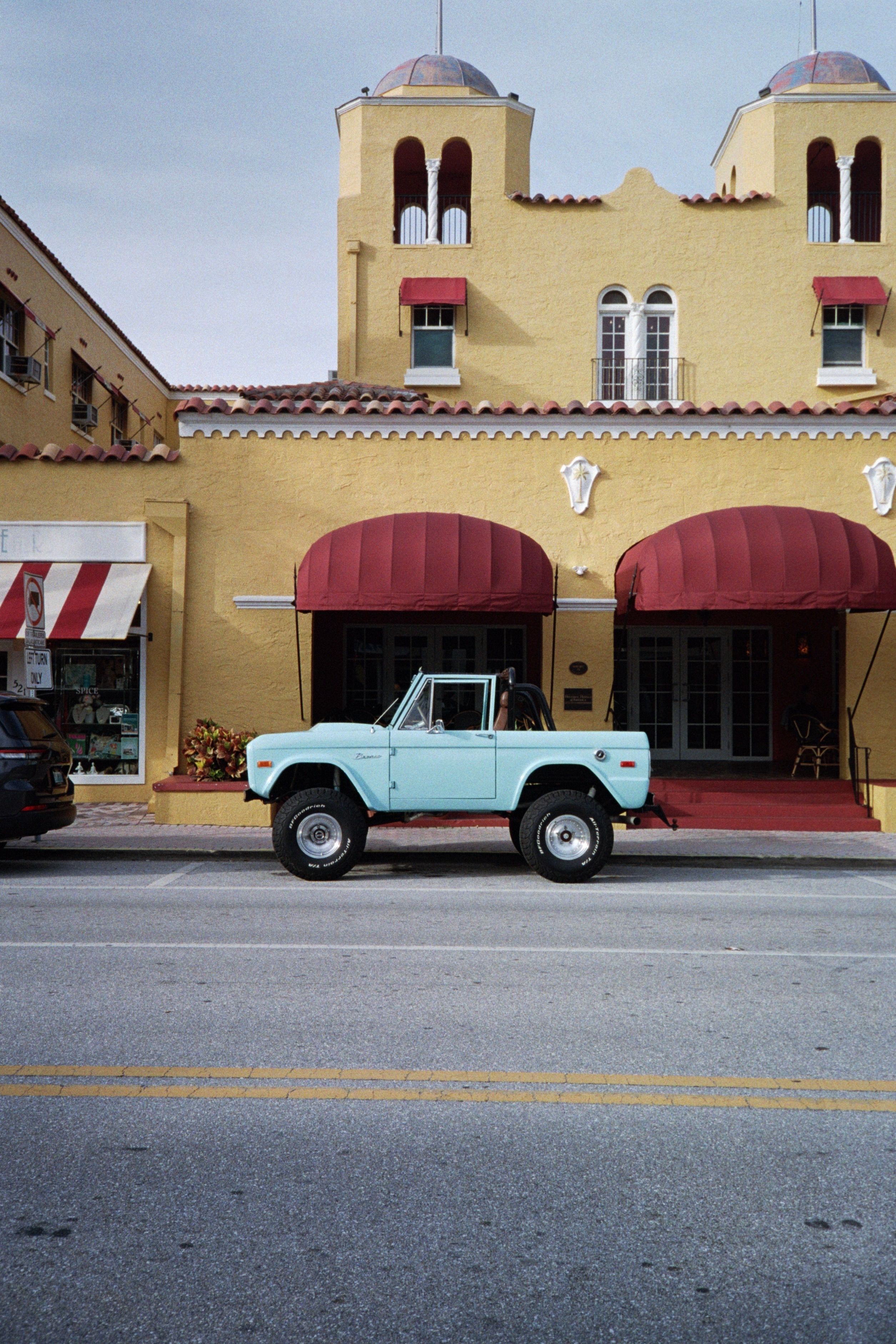 Vintage Blue SUV Parked by Historic Building · Free Stock Photo