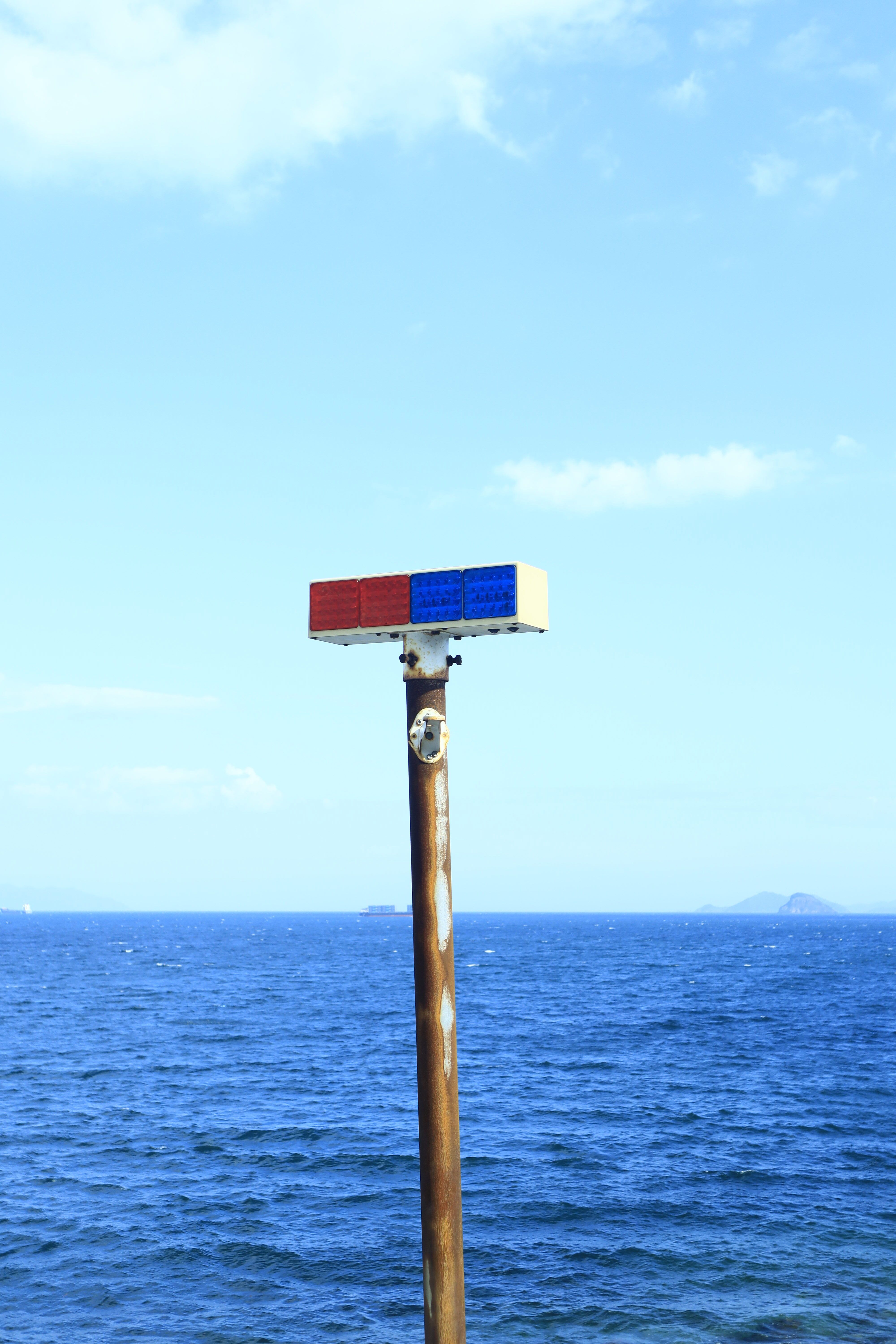Minimalist Coastal Pole Against Blue Ocean · Free Stock Photo