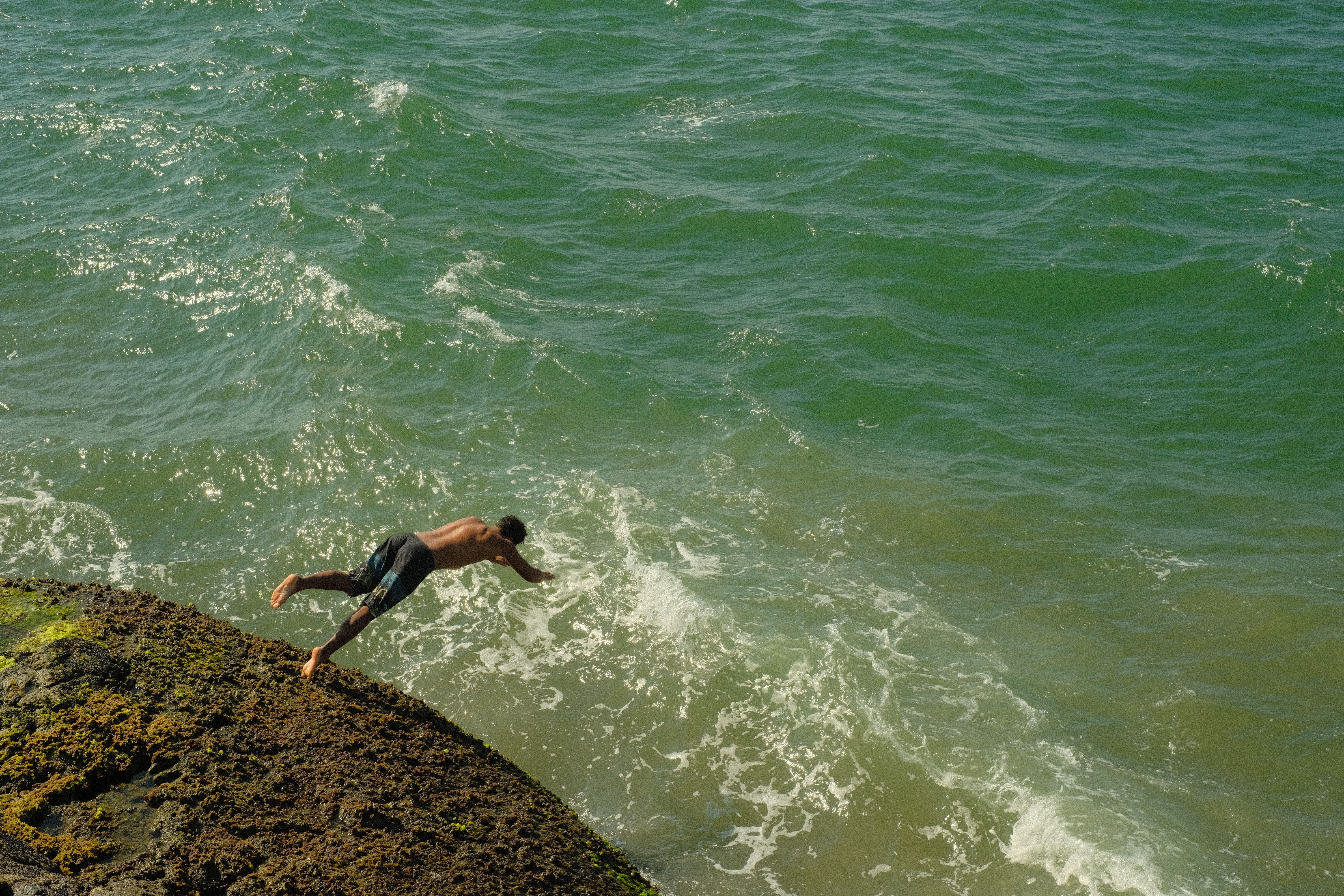 Man Jumping into Atlantic Ocean from Itapoá Rocks · Free Stock Photo