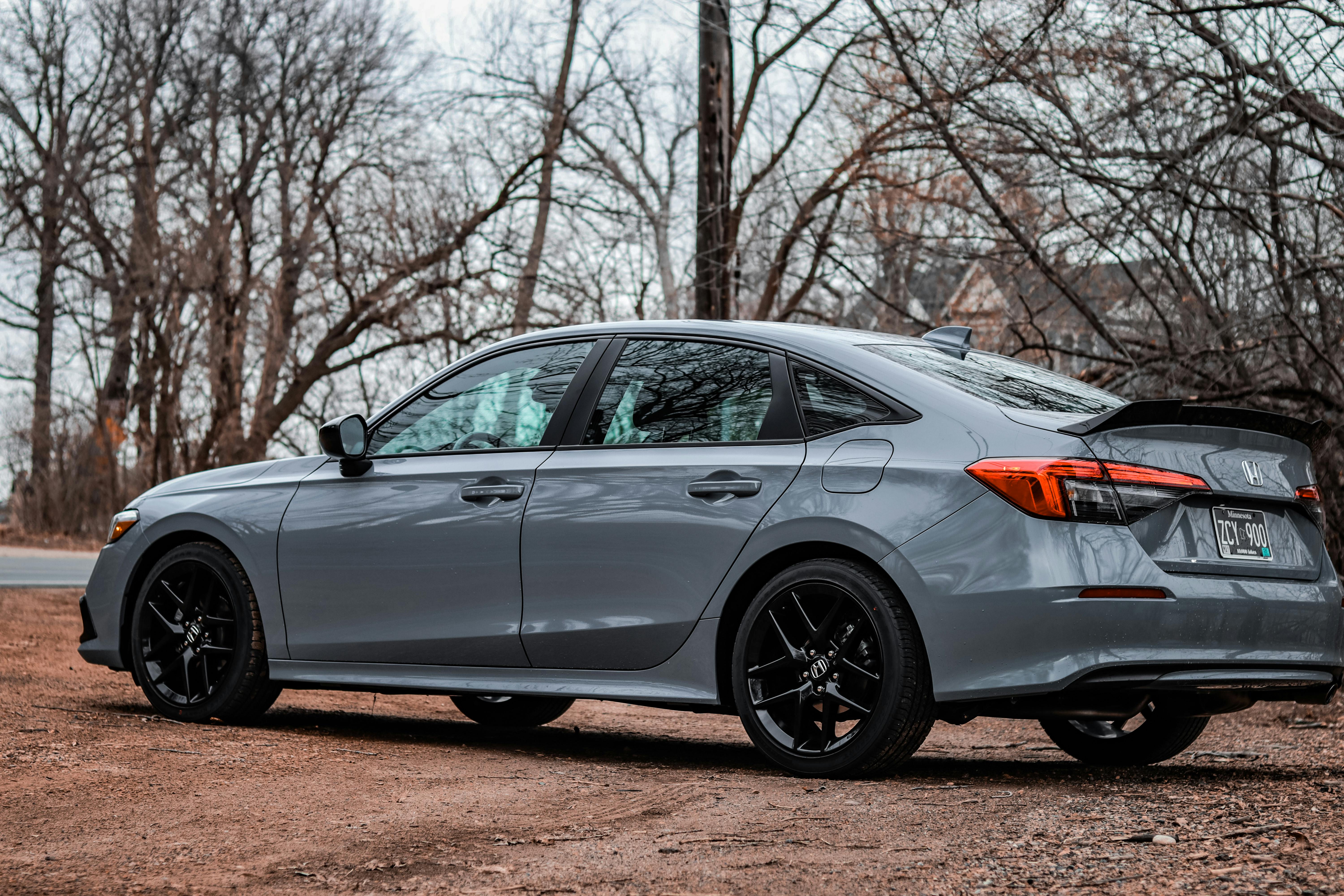 Sleek Grey Sedan in a Leafless Winter Setting · Free Stock Photo