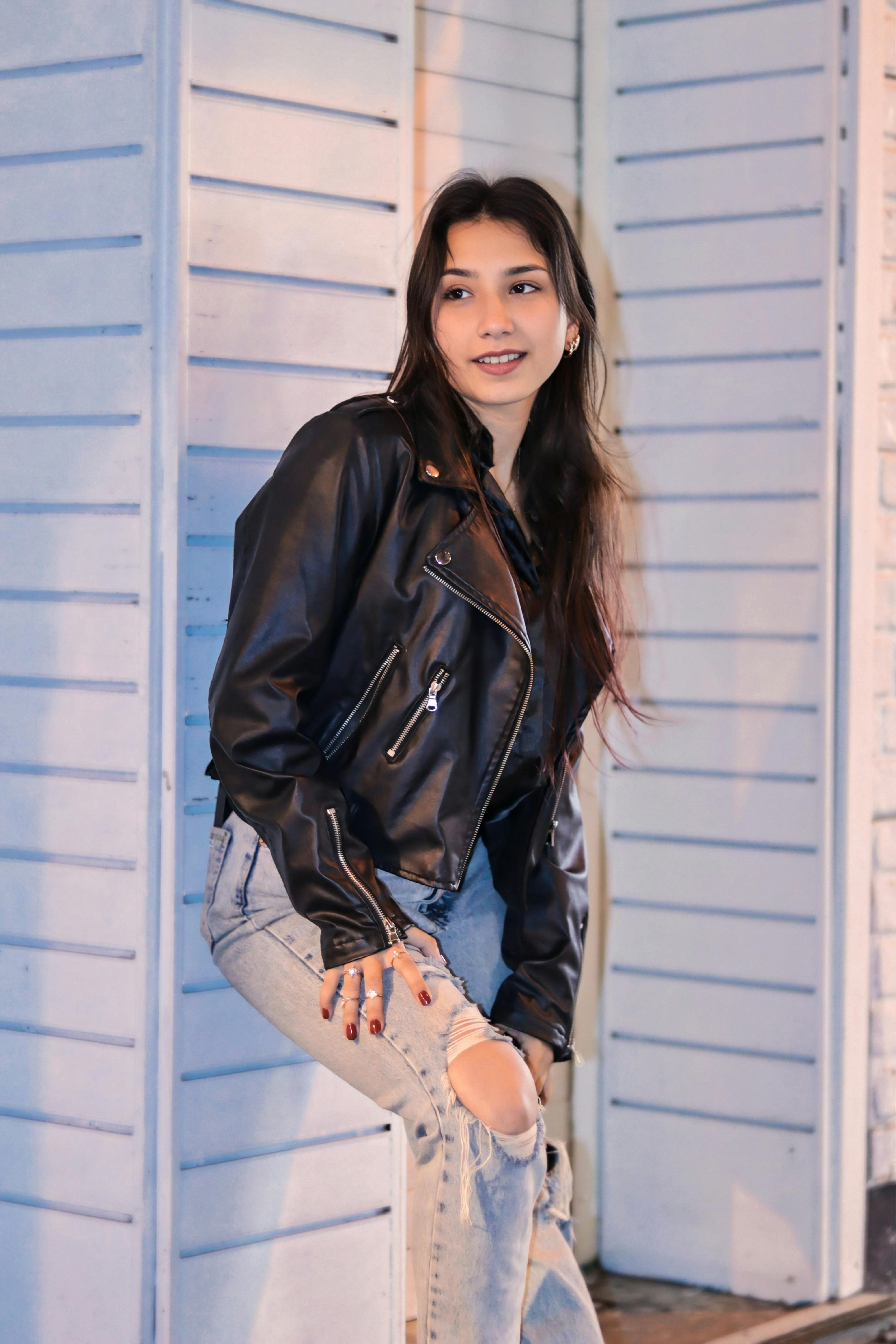 Young Woman in Leather Jacket Leaning on Shutters · Free Stock Photo