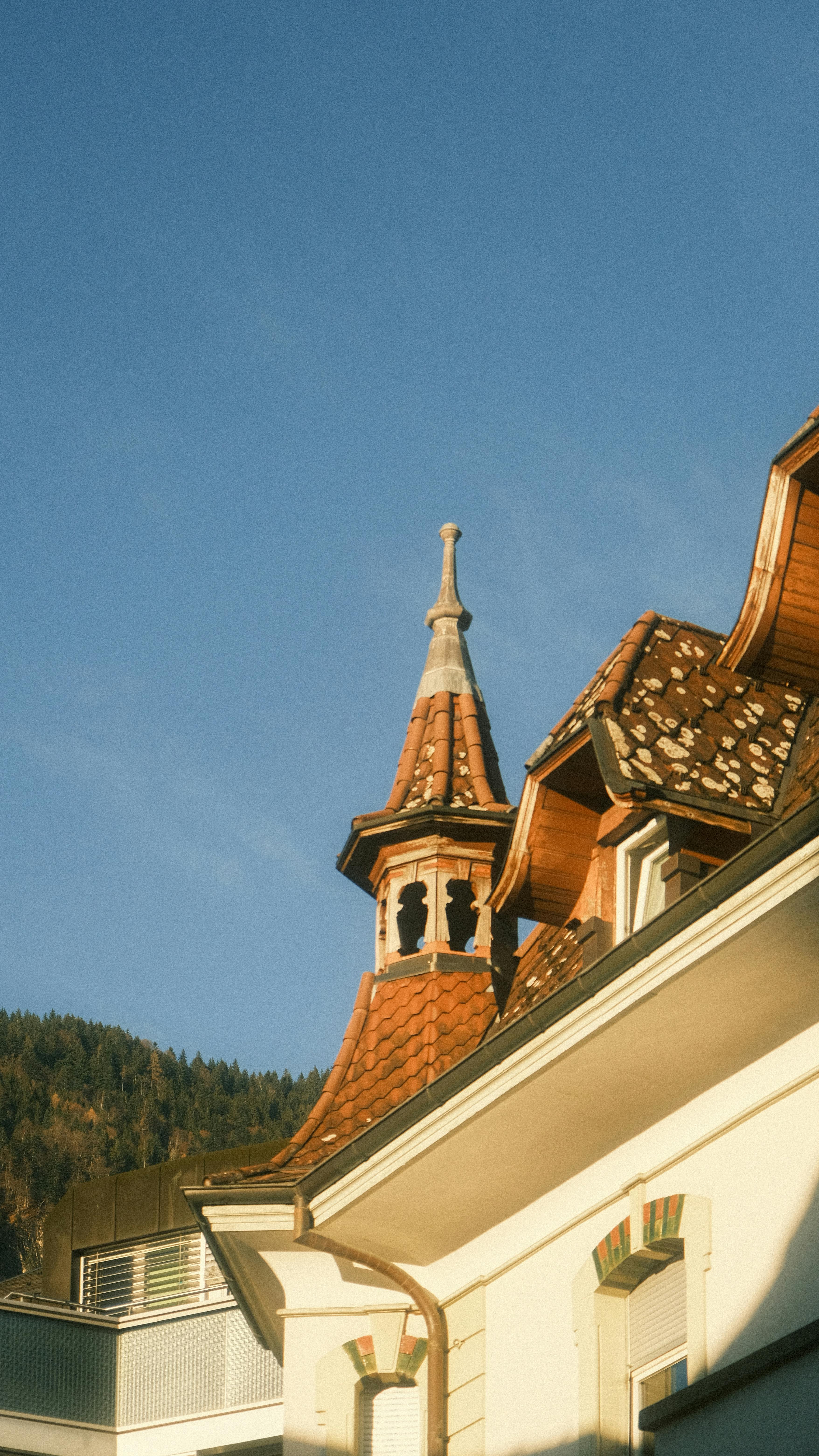 Charming Alpine Roof with Wooden Spire at Sunrise · Free Stock Photo