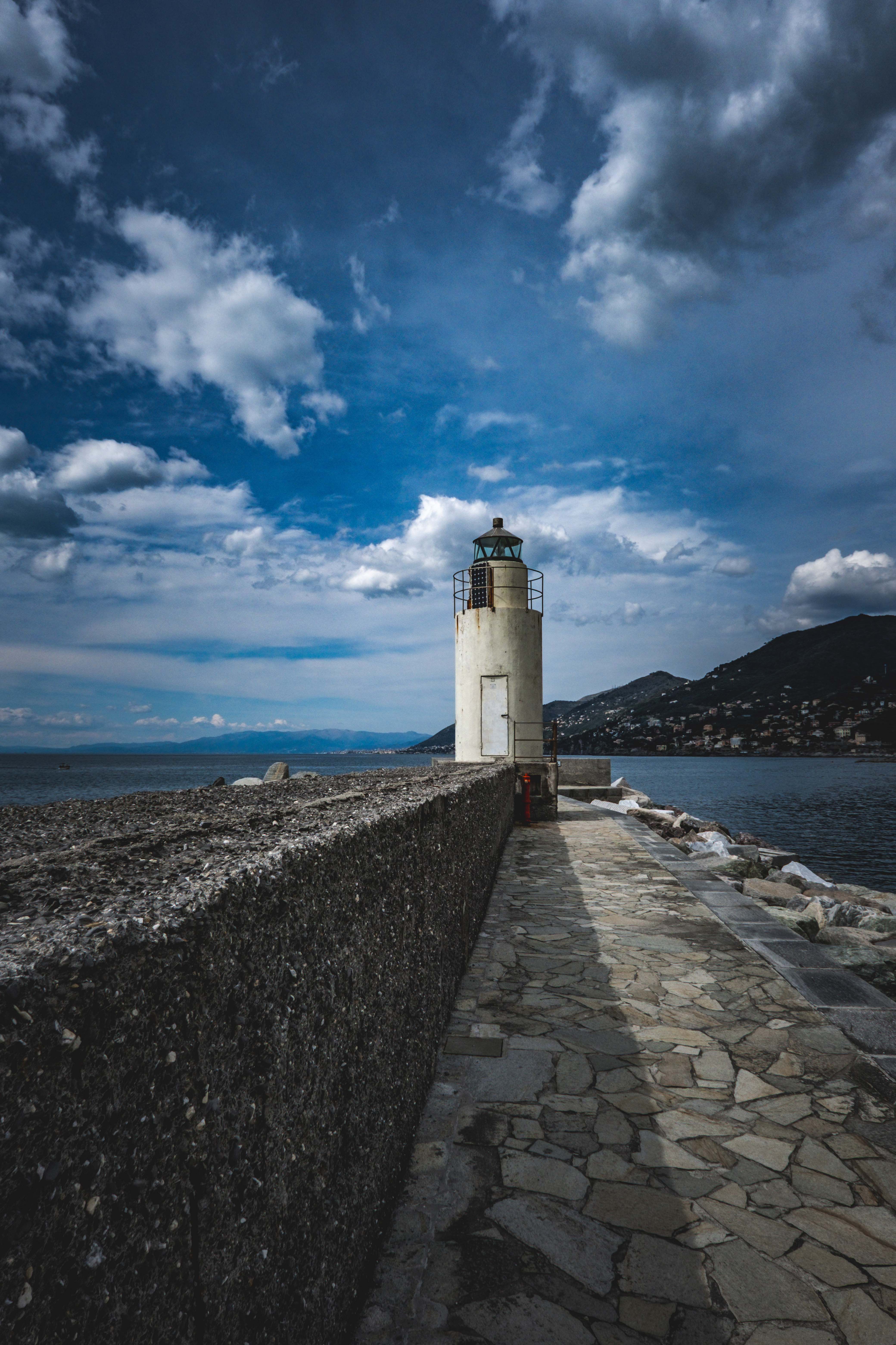 Dramatic Coastal Lighthouse Under Blue Sky · Free Stock Photo