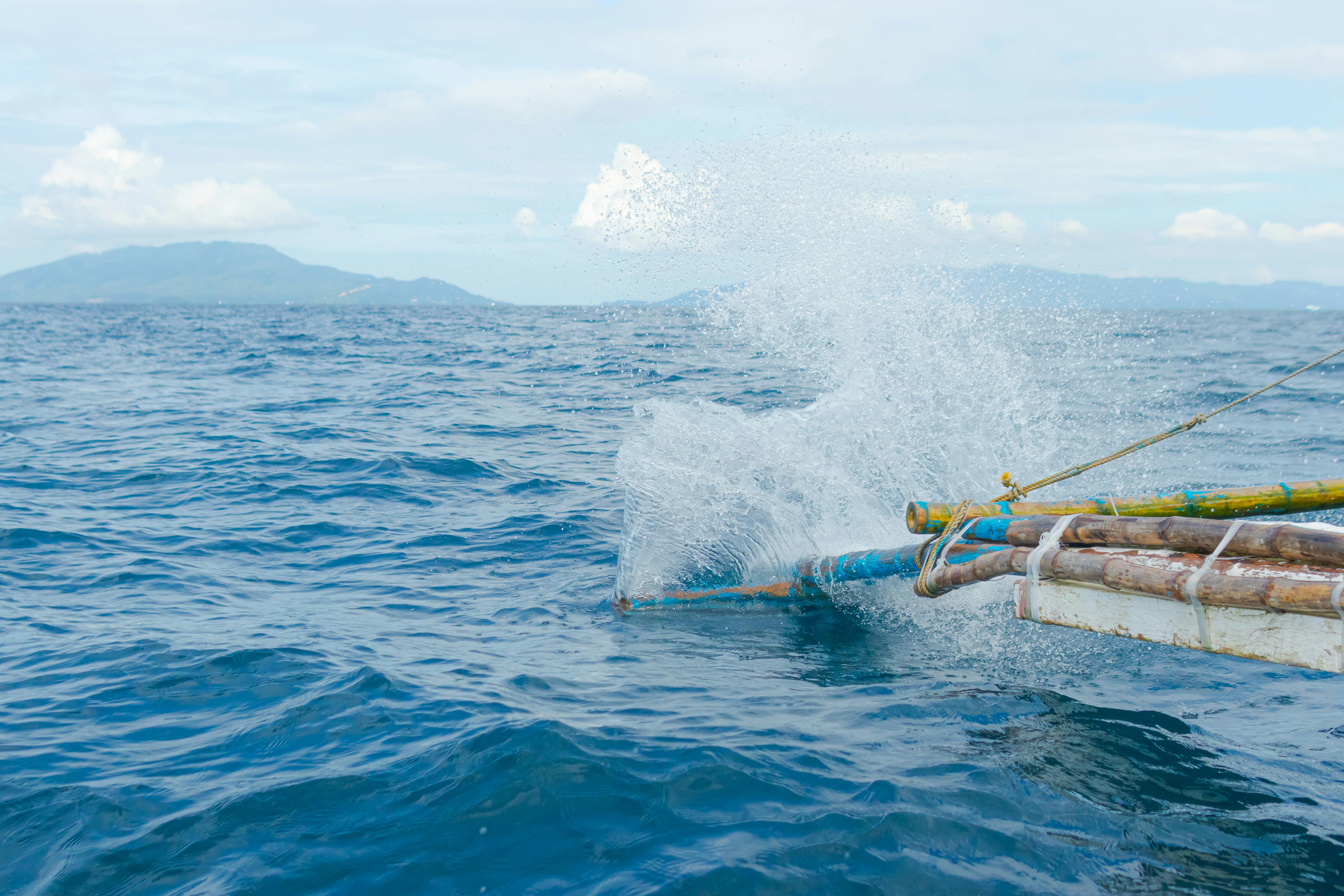 Traditional Canoe Navigating Open Sea Waves · Free Stock Photo