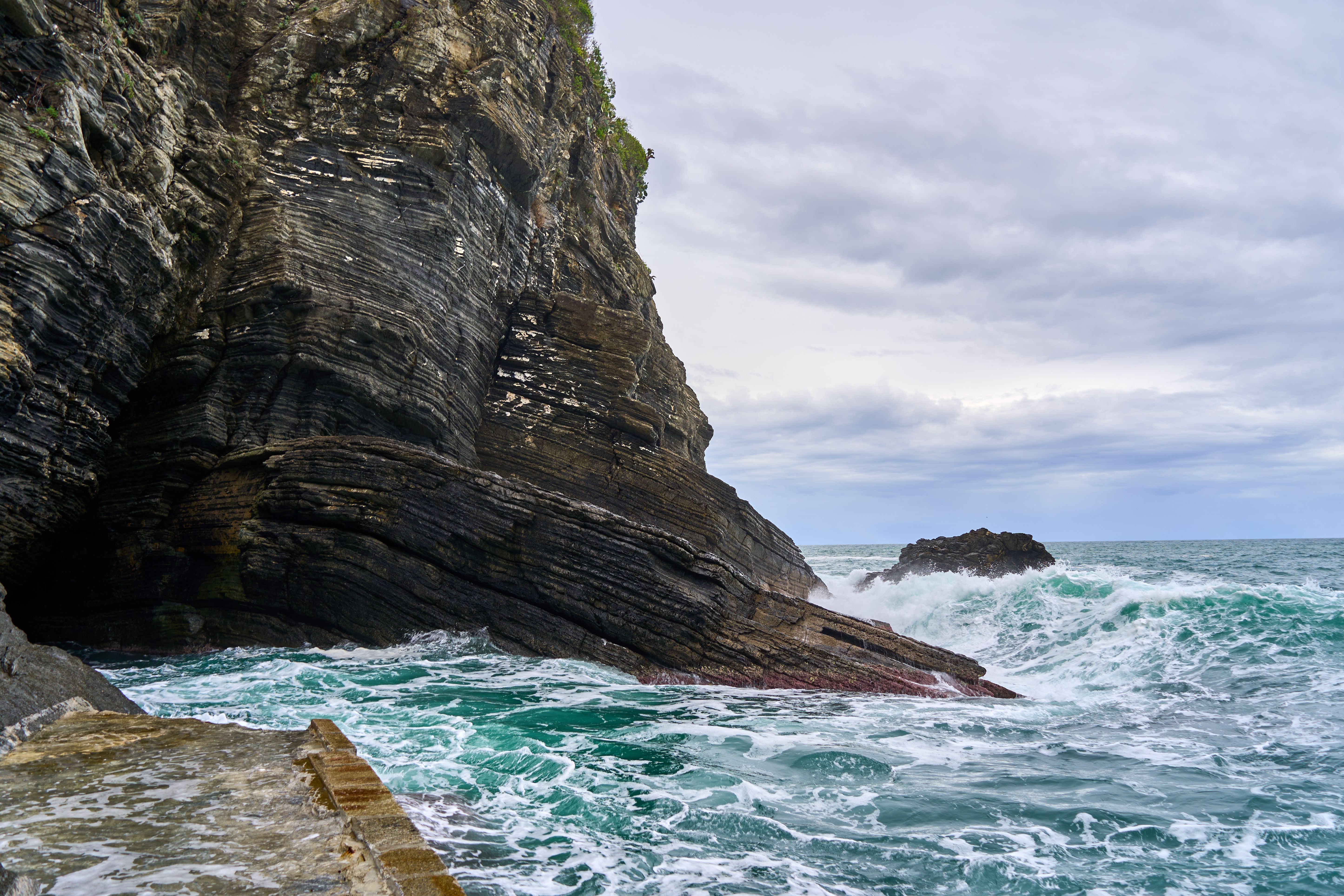 Dramatic Coastal Cliffside and Turbulent Ocean Waves · Free Stock Photo