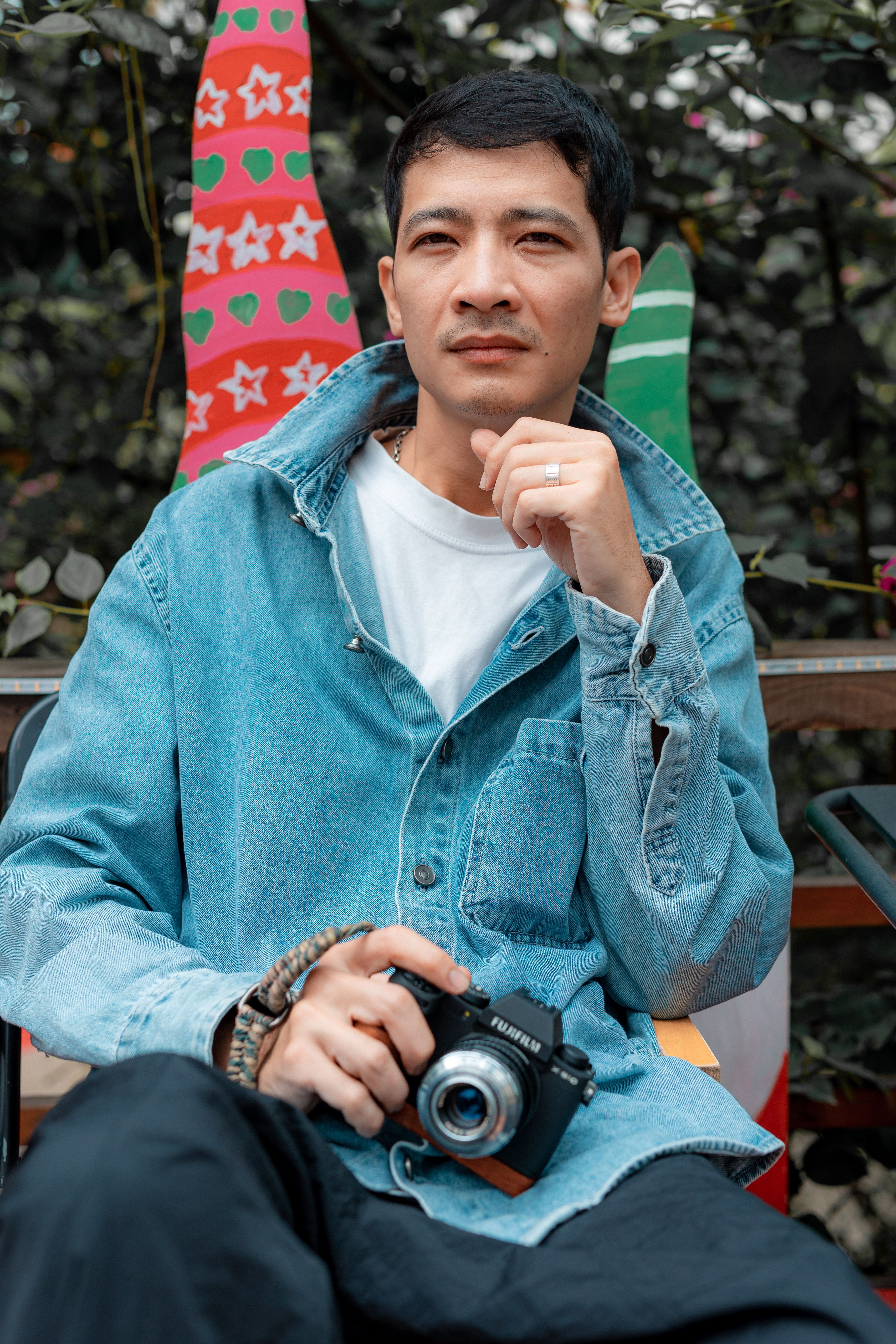 Man Holding Fuji Camera in Outdoor Setting · Free Stock Photo