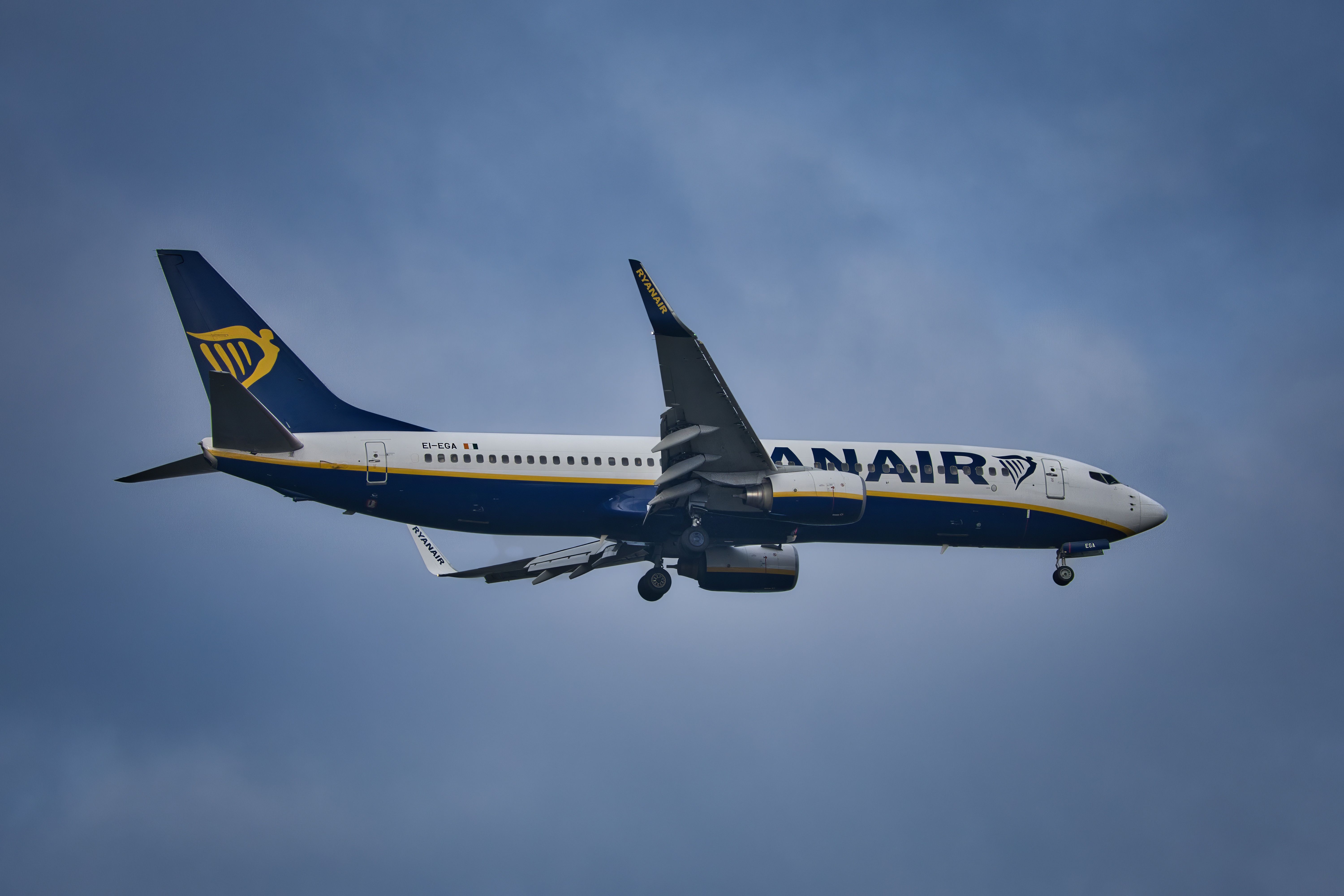 Ryanair Jet Flying Through Cloudy Sky · Free Stock Photo