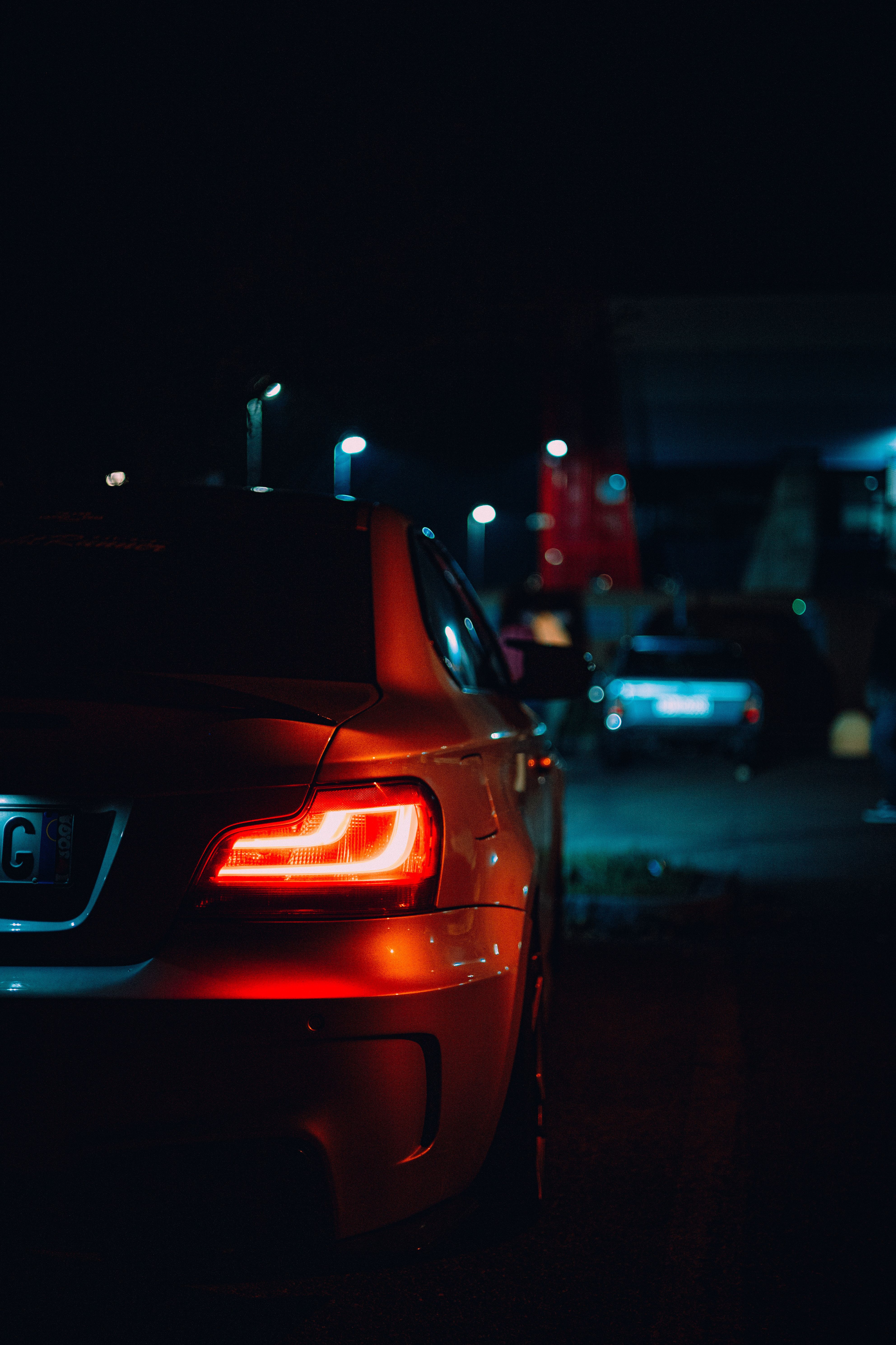 Moody Night Scene of Car with Red Tail Lights · Free Stock Photo