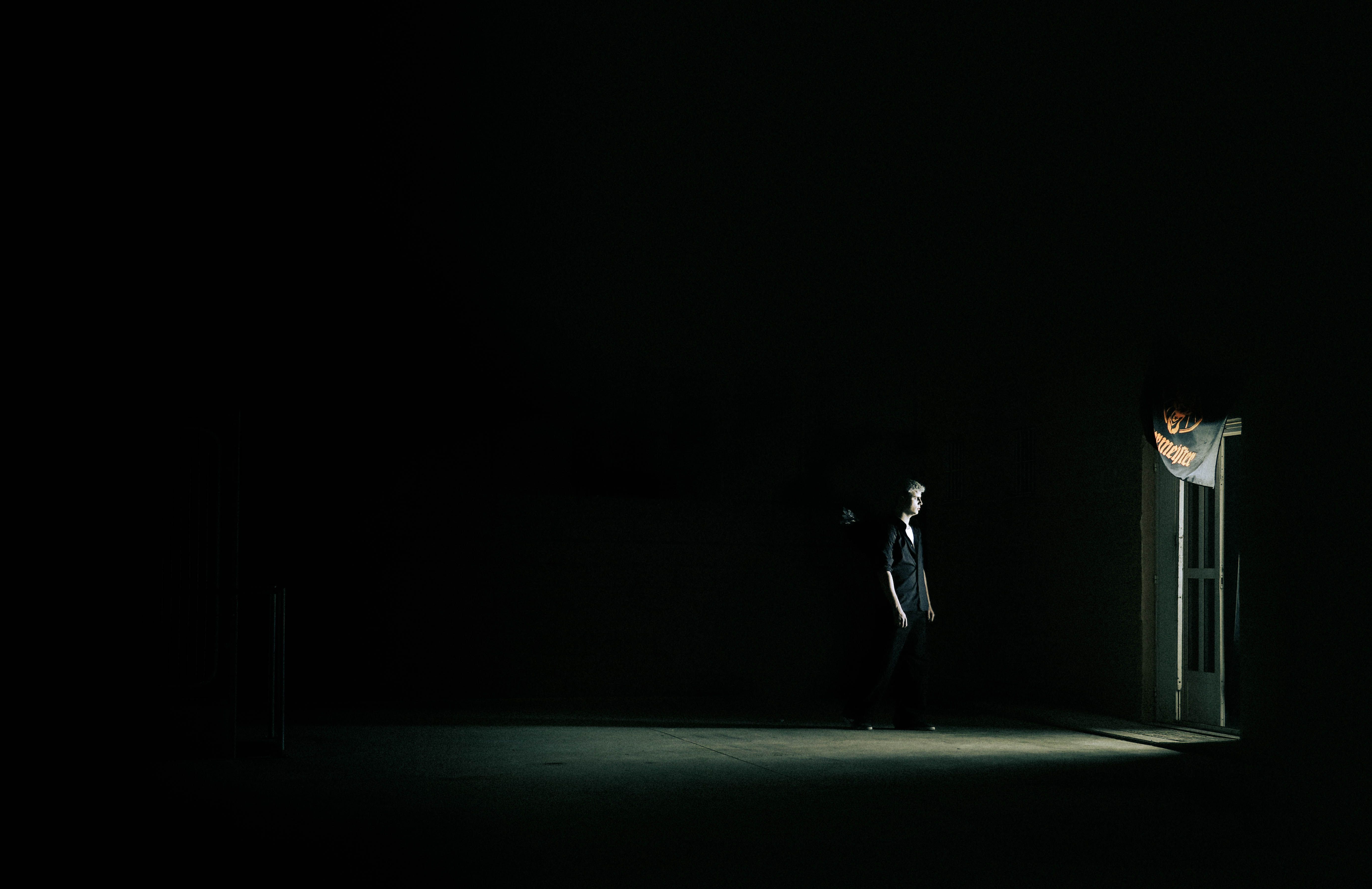 Person Standing in a Dark Room with Dim Lighting · Free Stock Photo