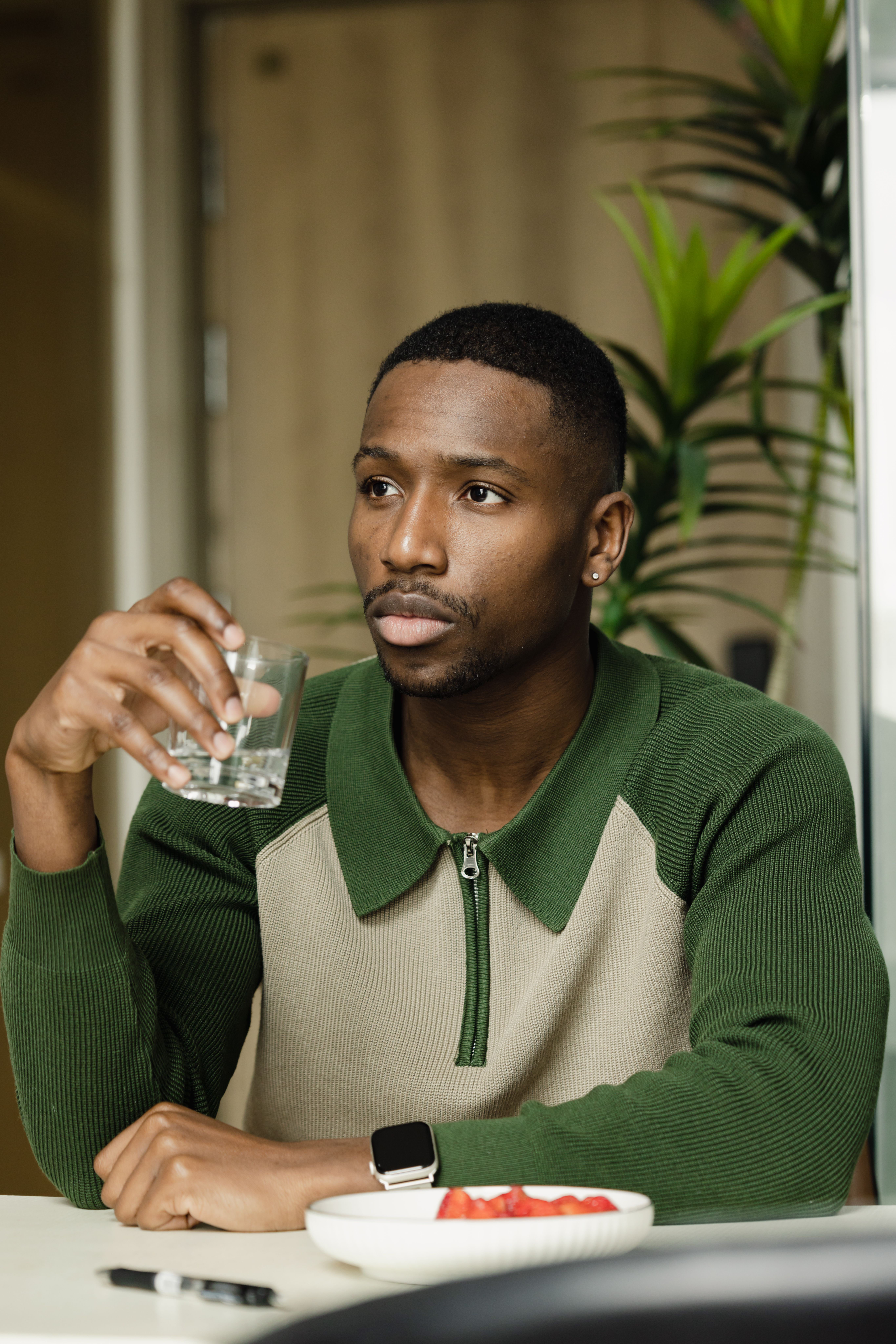 Man in Green Sweater Holding a Glass of Water · Free Stock Photo