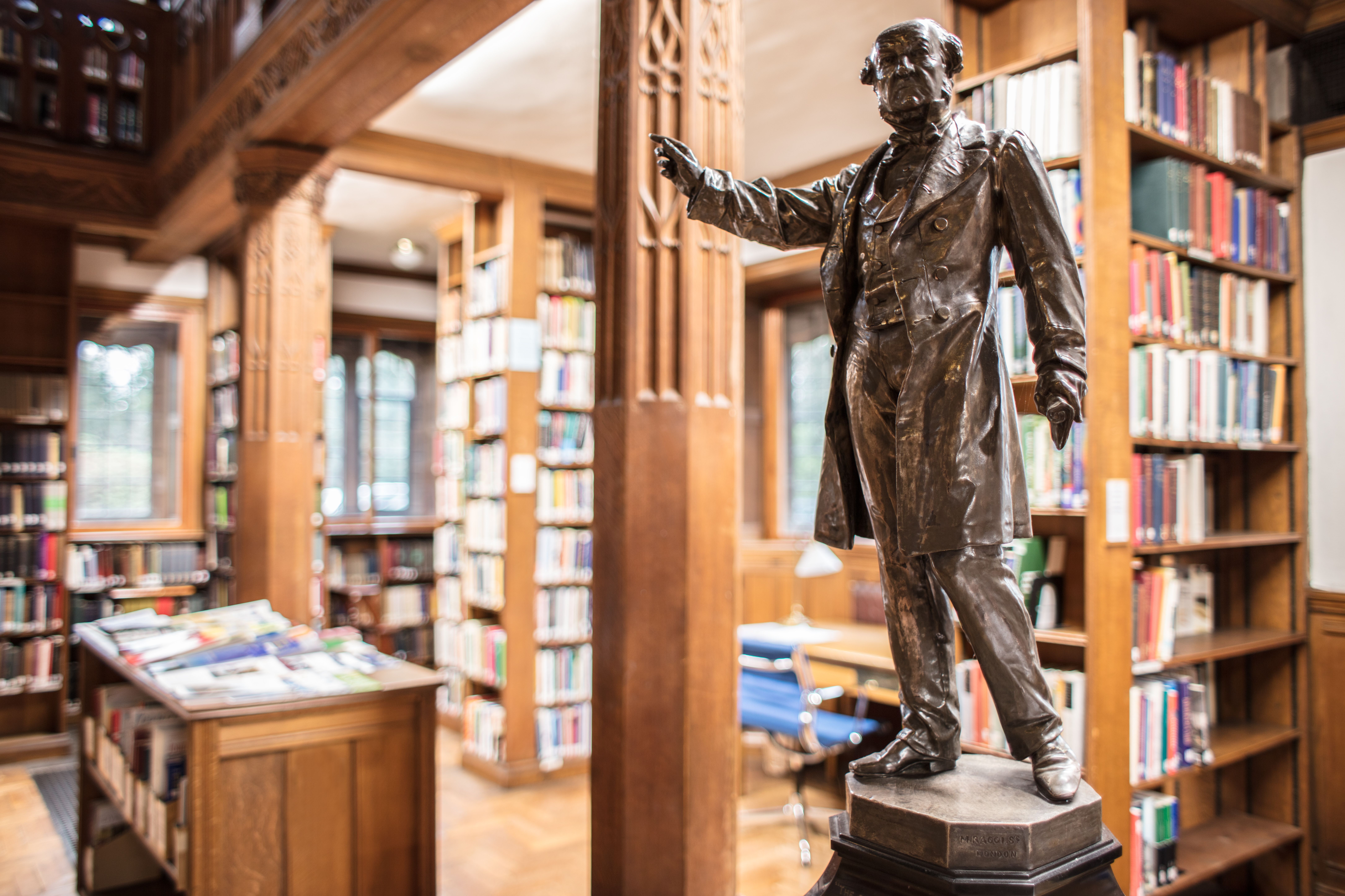 Classic Library Interior with Historic Statue · Free Stock Photo
