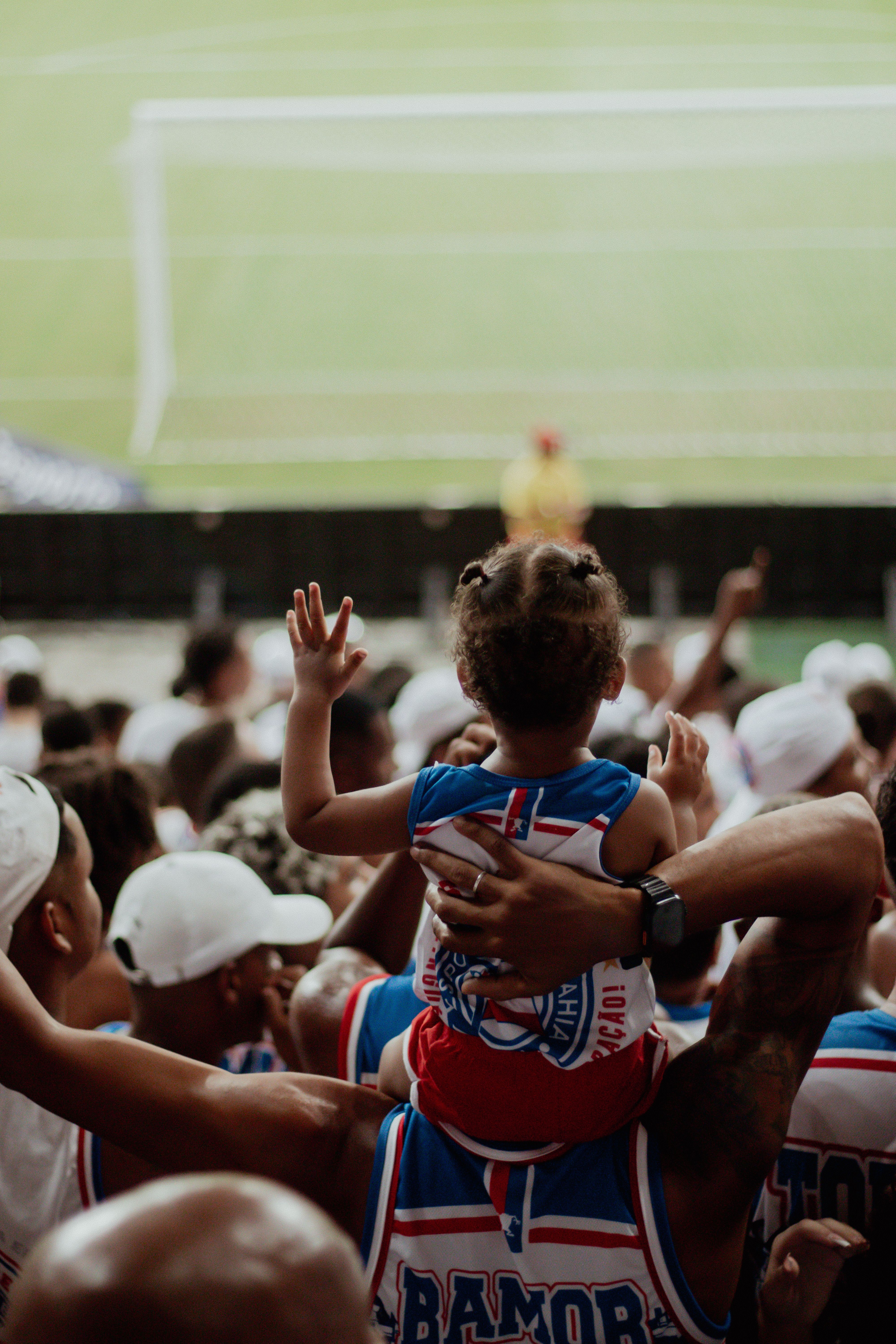 Excited Football Fans Raising Child at Stadium · Free Stock Photo