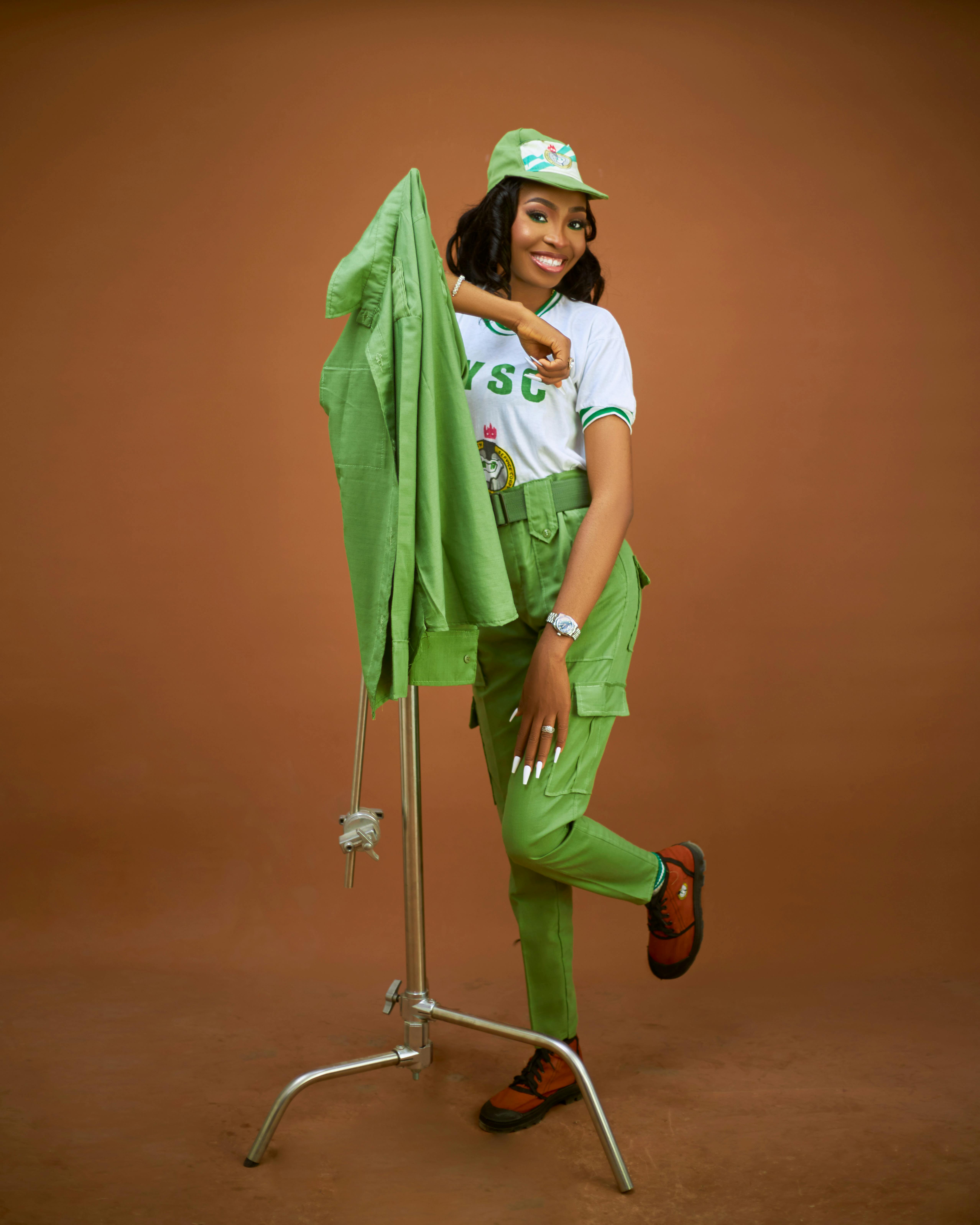 Female Youth in NYSC Uniform Against Brown Background · Free Stock Photo