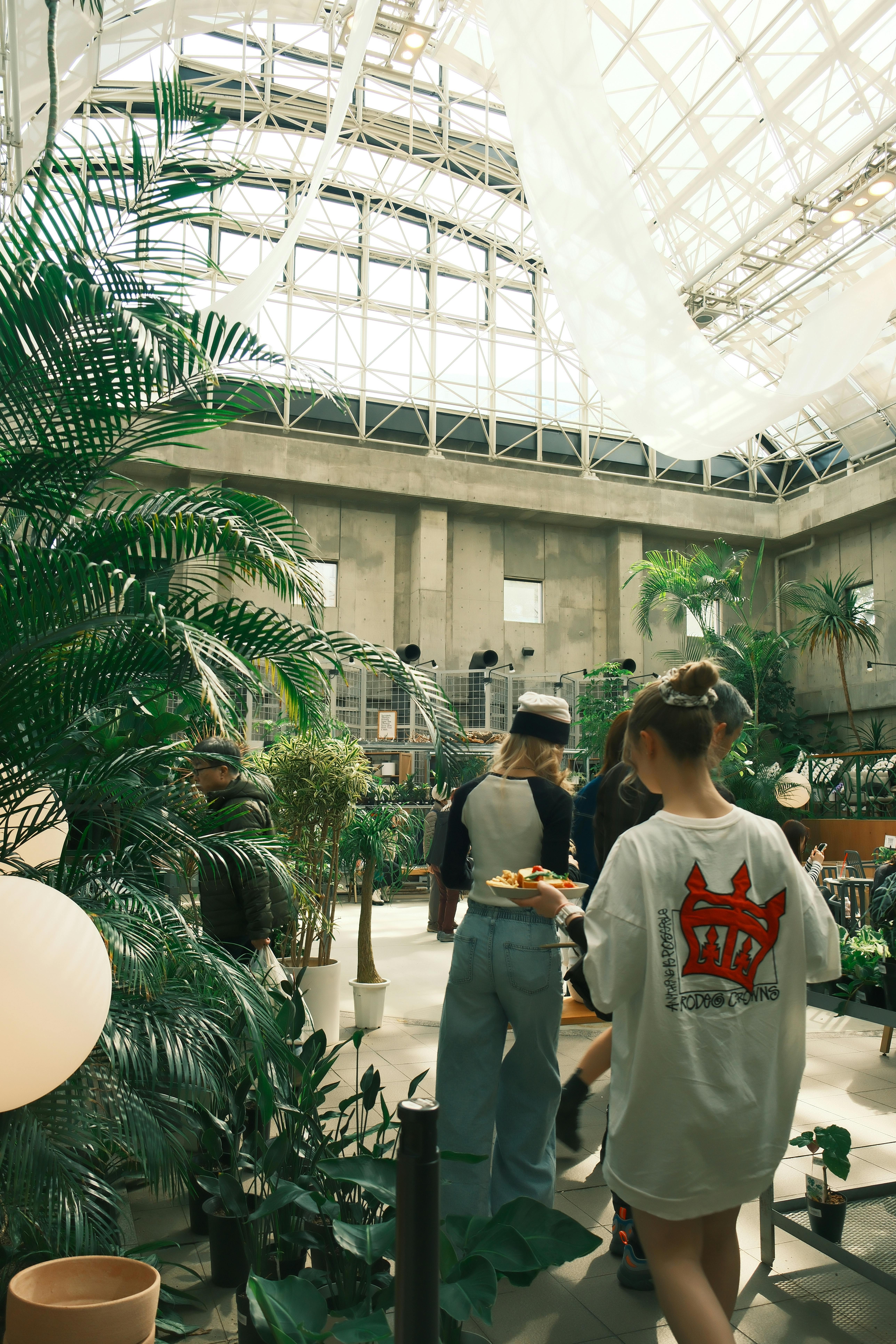 Indoor Garden with People Exploring Plants · Free Stock Photo