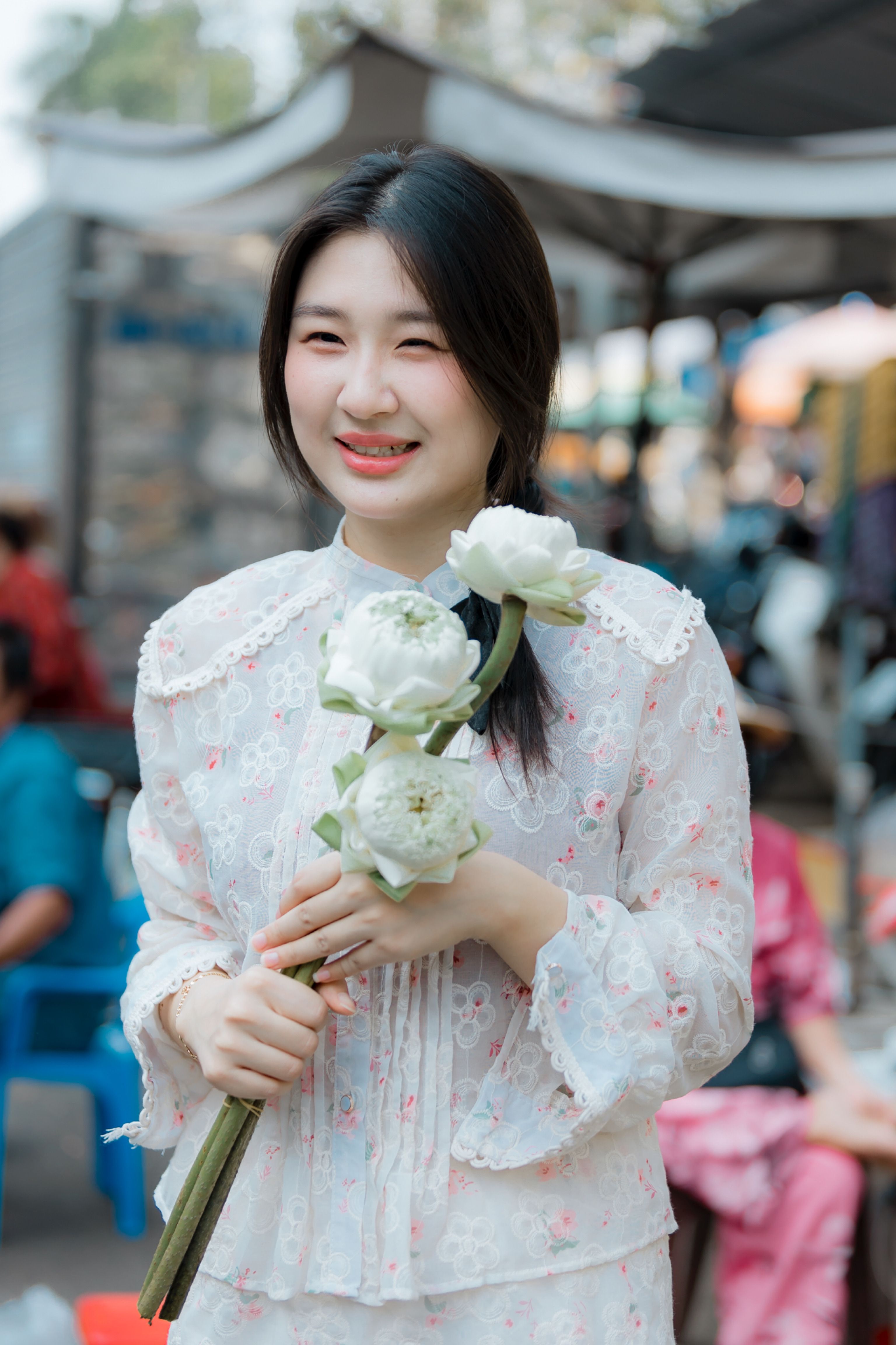 Young Woman Smiling with White Lotus Flowers · Free Stock Photo