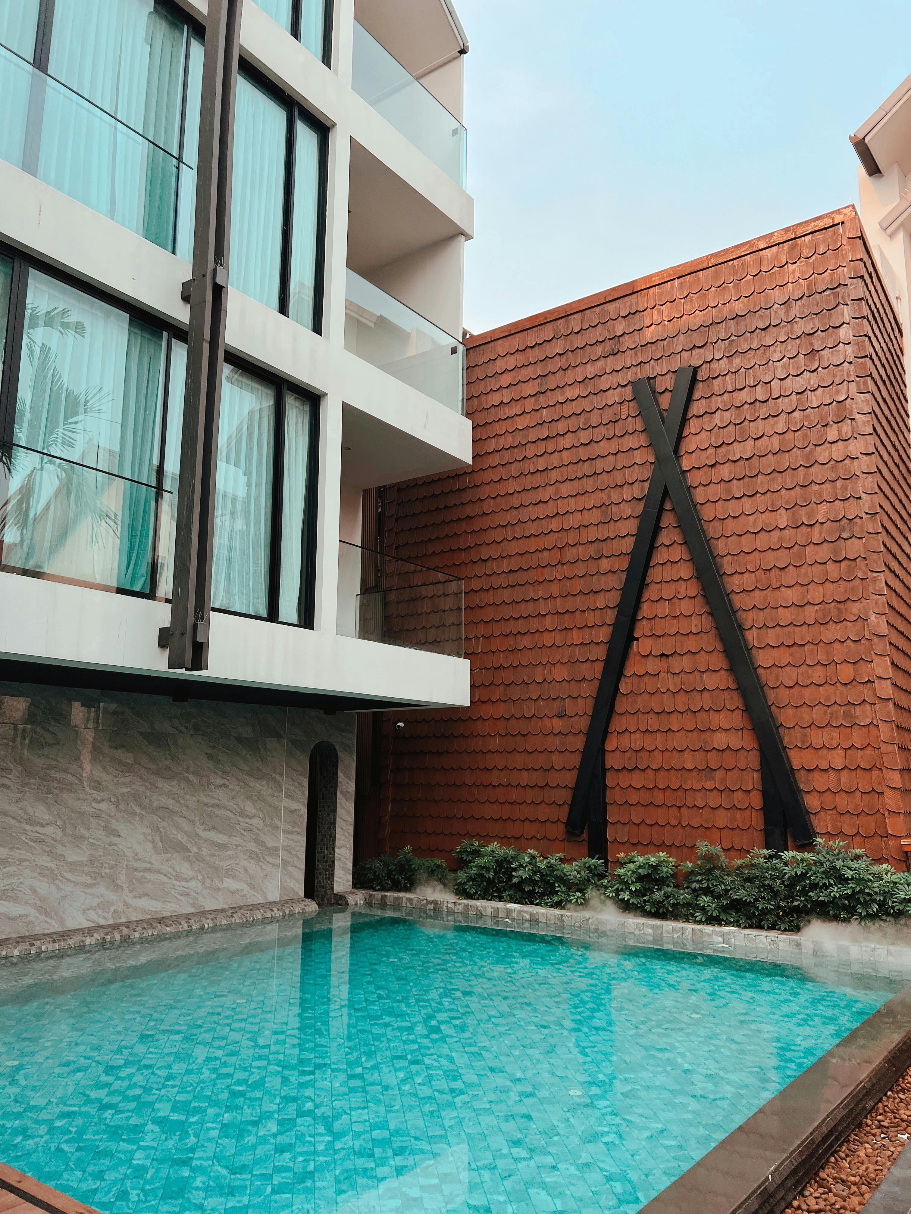 Modern Hotel Exterior with Poolside View · Free Stock Photo