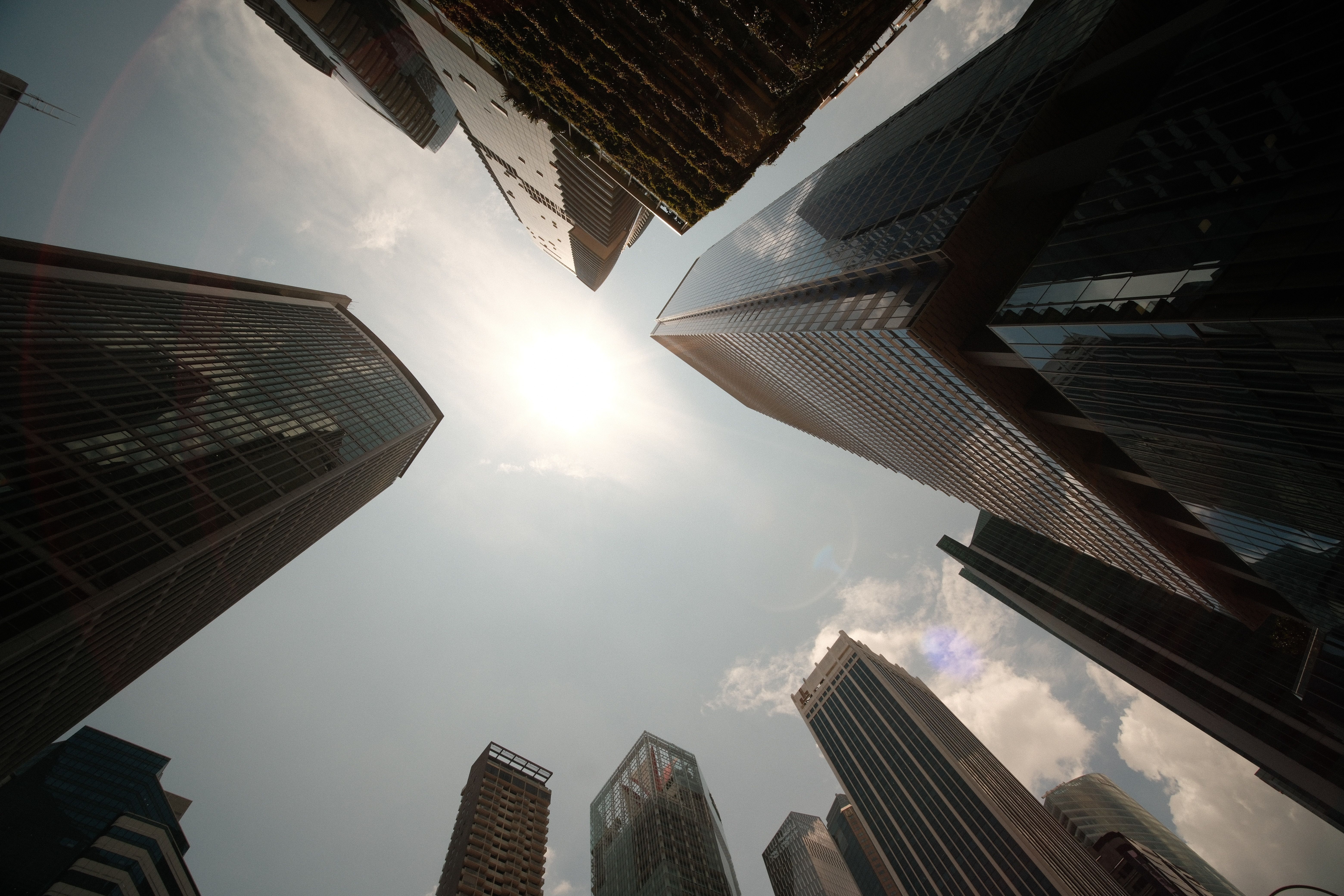 Dramatic Skyscraper Skyline against Bright Sun · Free Stock Photo