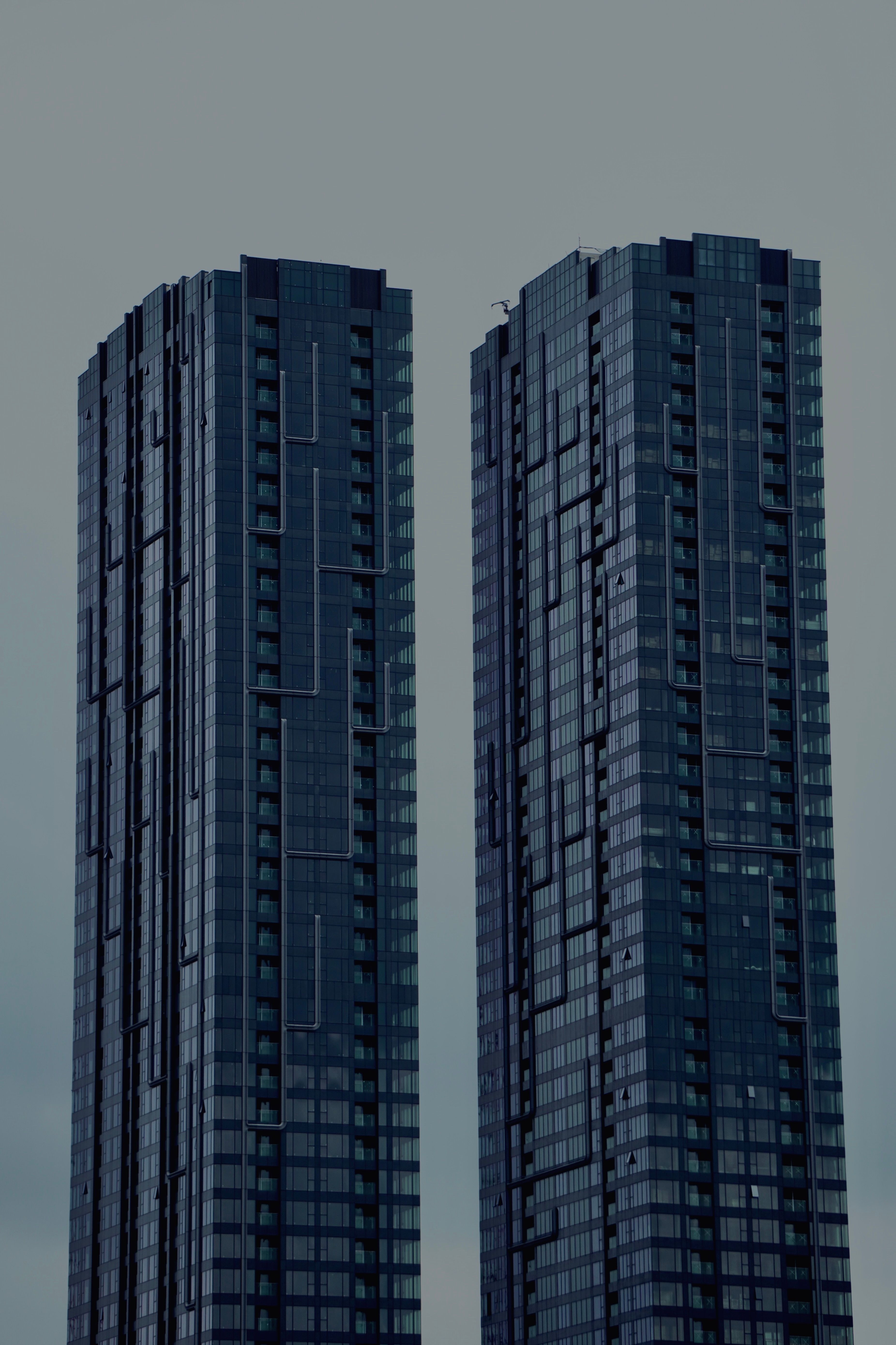 Modern Twin Skyscrapers Against Overcast Sky · Free Stock Photo