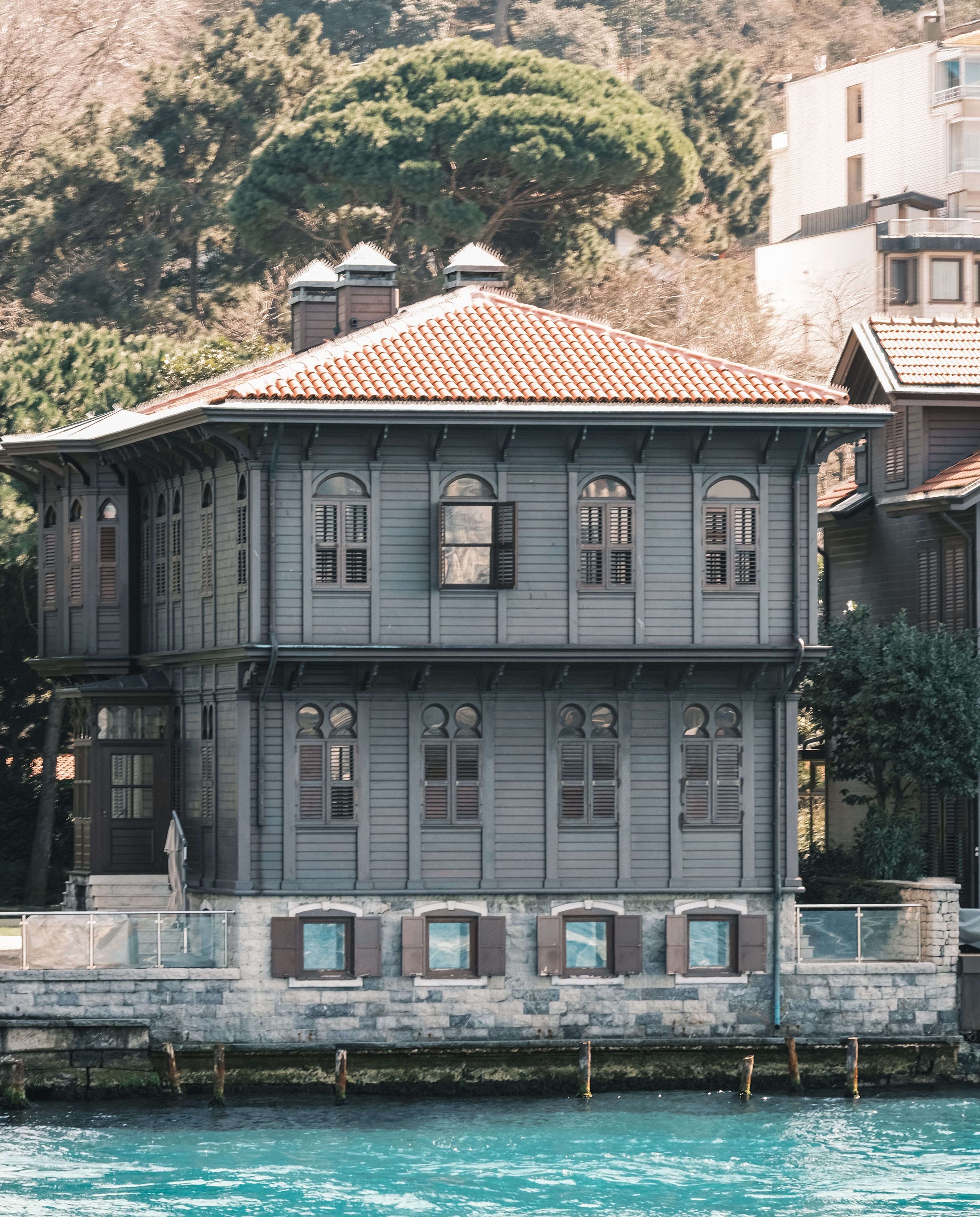 Traditional Waterfront Mansion with Red Roof · Free Stock Photo