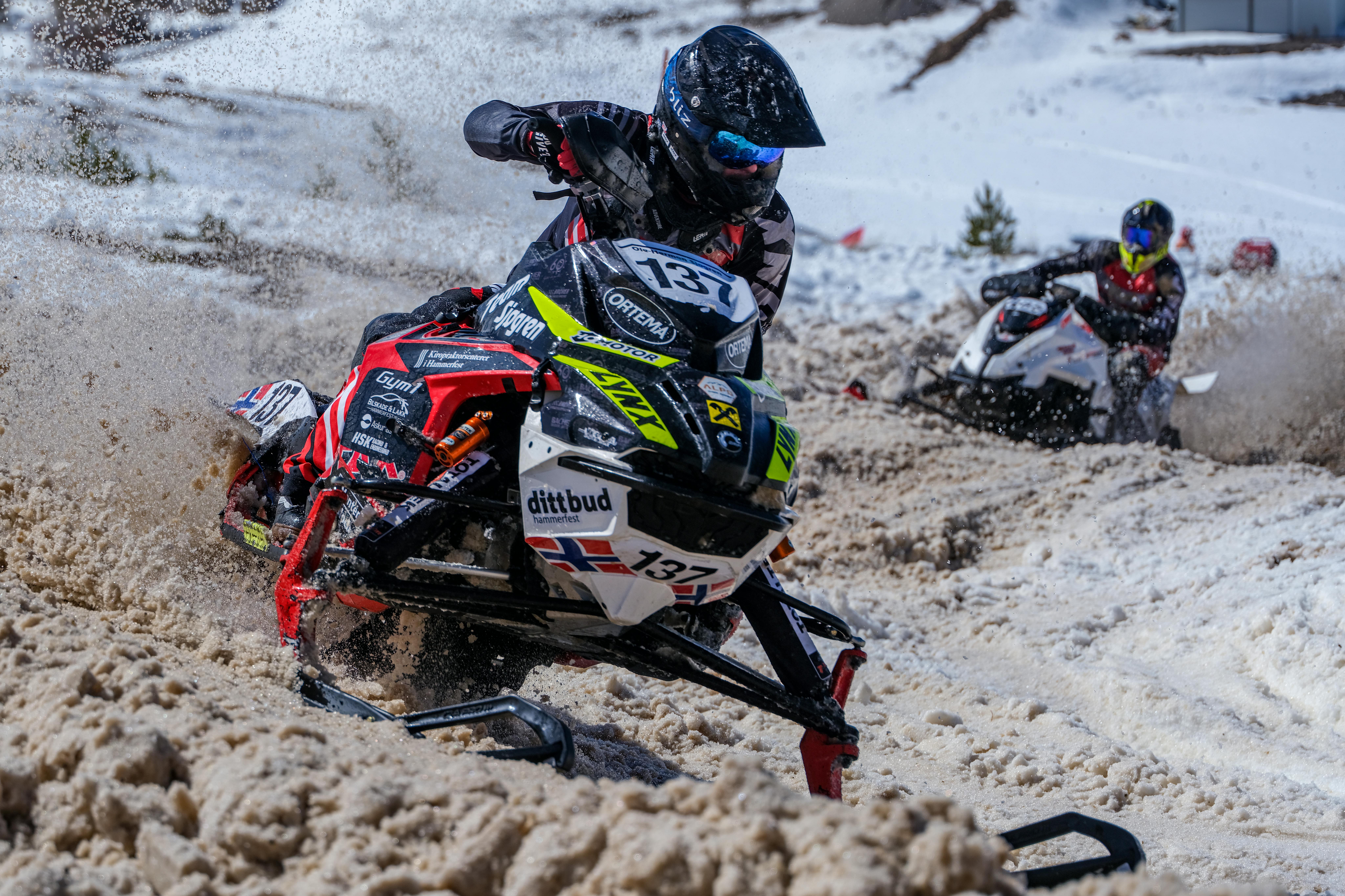 Dynamic Snowmobile Race in Snowy Terrain · Free Stock Photo