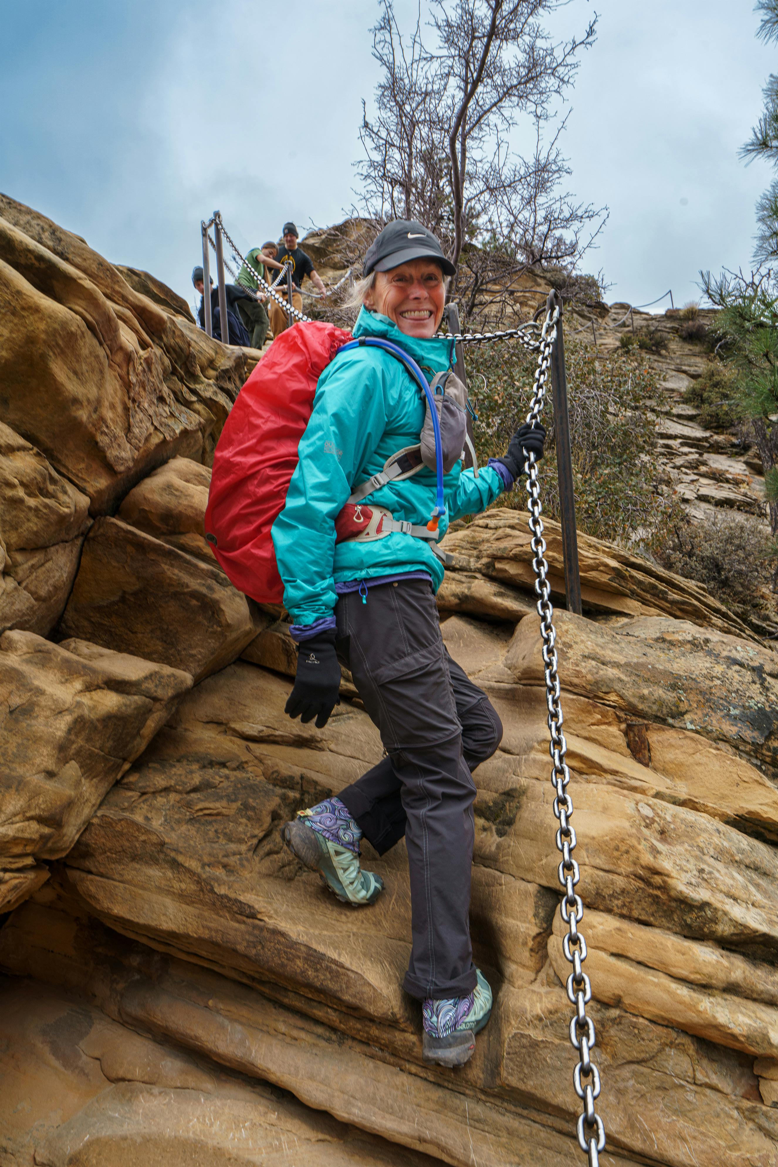 Woman Climbing Rocky Trail with Red Backpack · Free Stock Photo
