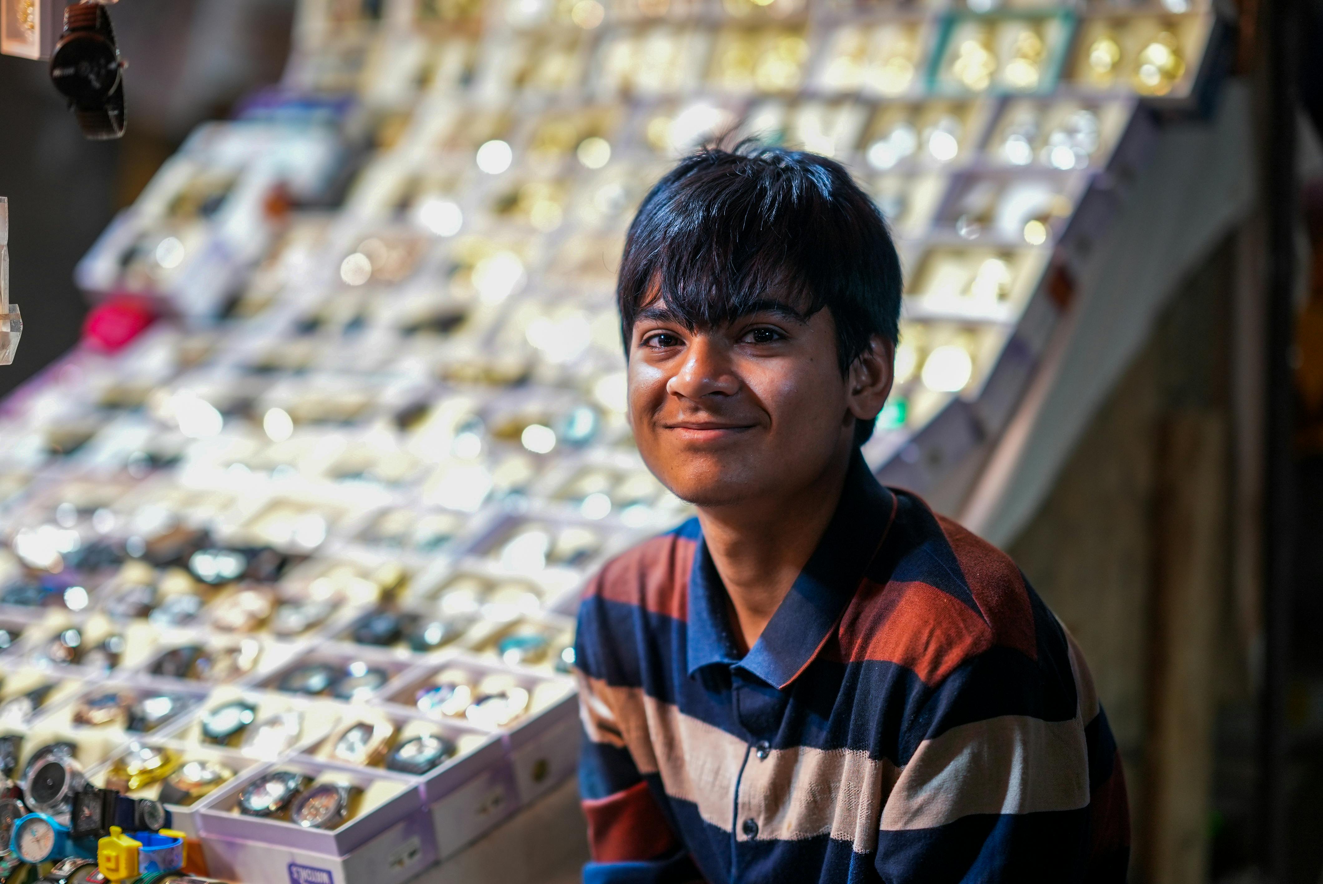 Young Shopkeeper Smiling at Jewelry Stall · Free Stock Photo