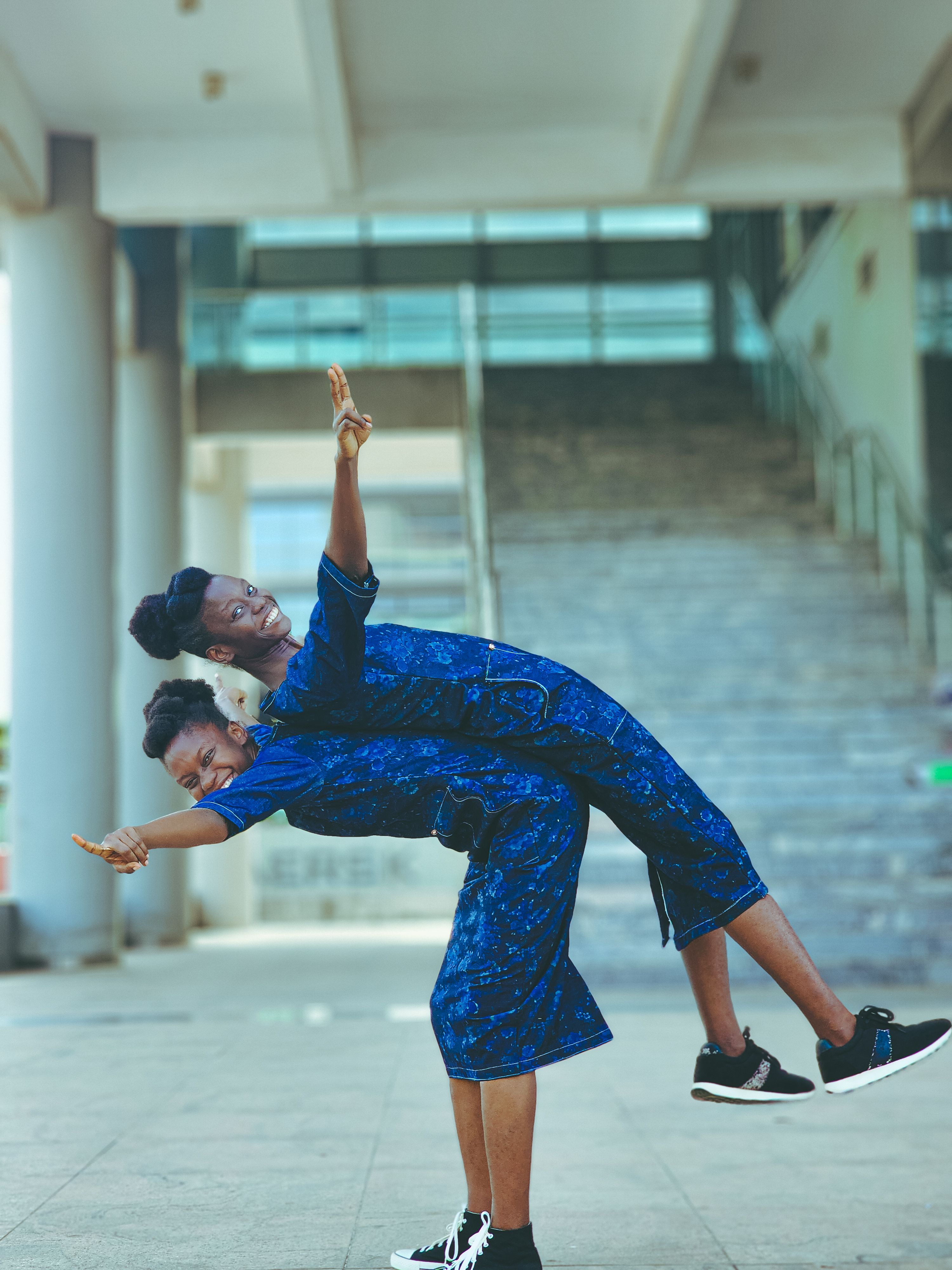 Joyful Duo Performing Balance Pose Outdoors · Free Stock Photo
