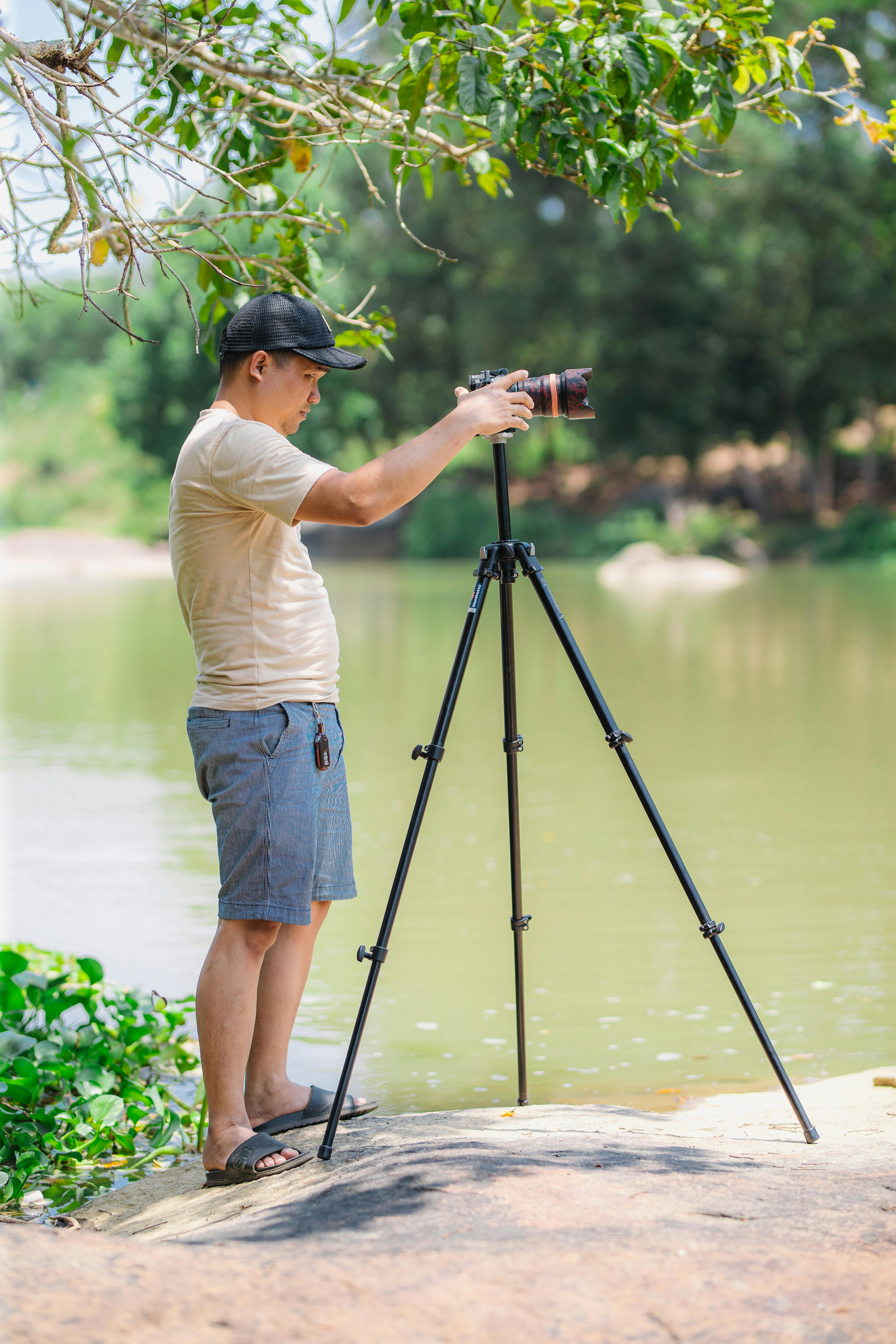 Photographer Setting Up Camera by Scenic River · Free Stock Photo