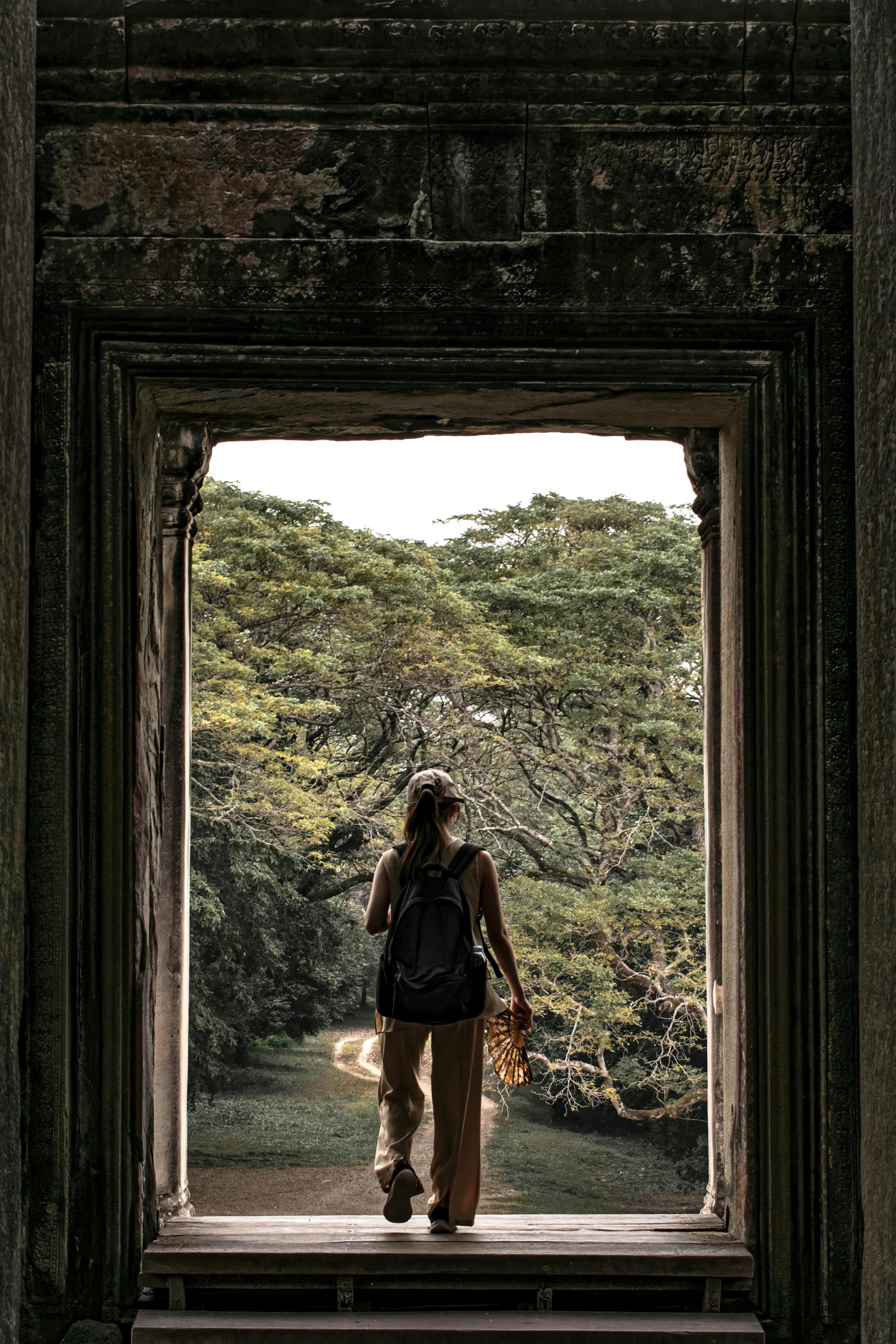 Traveler Exploring Ancient Angkor Wat Temple Gateway · Free Stock Photo