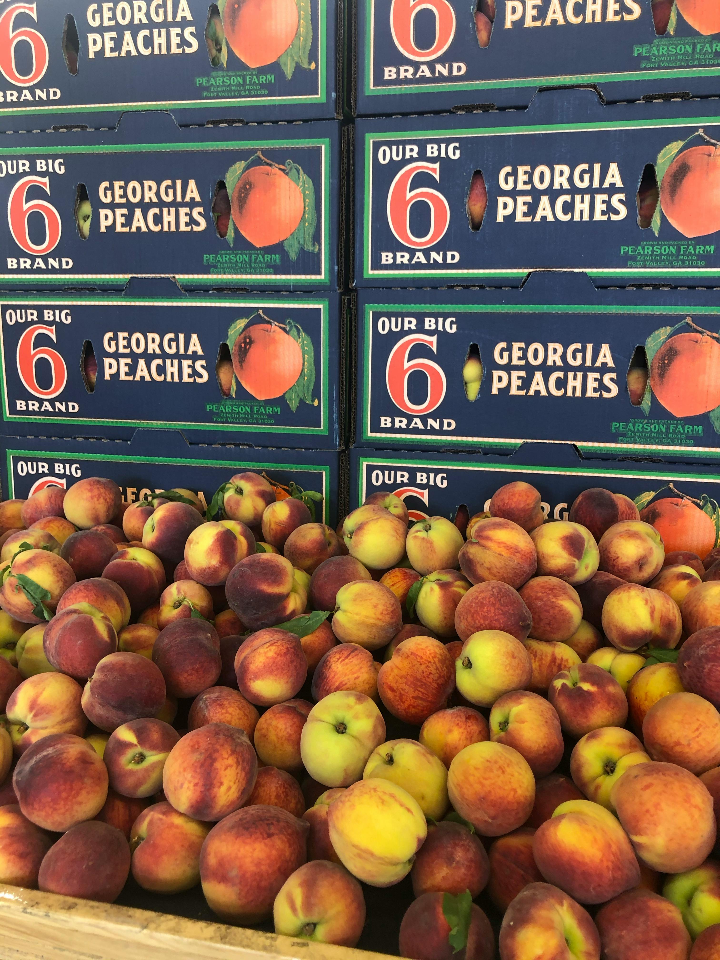 Fresh Georgia Peaches in Blue Boxes Display · Free Stock Photo