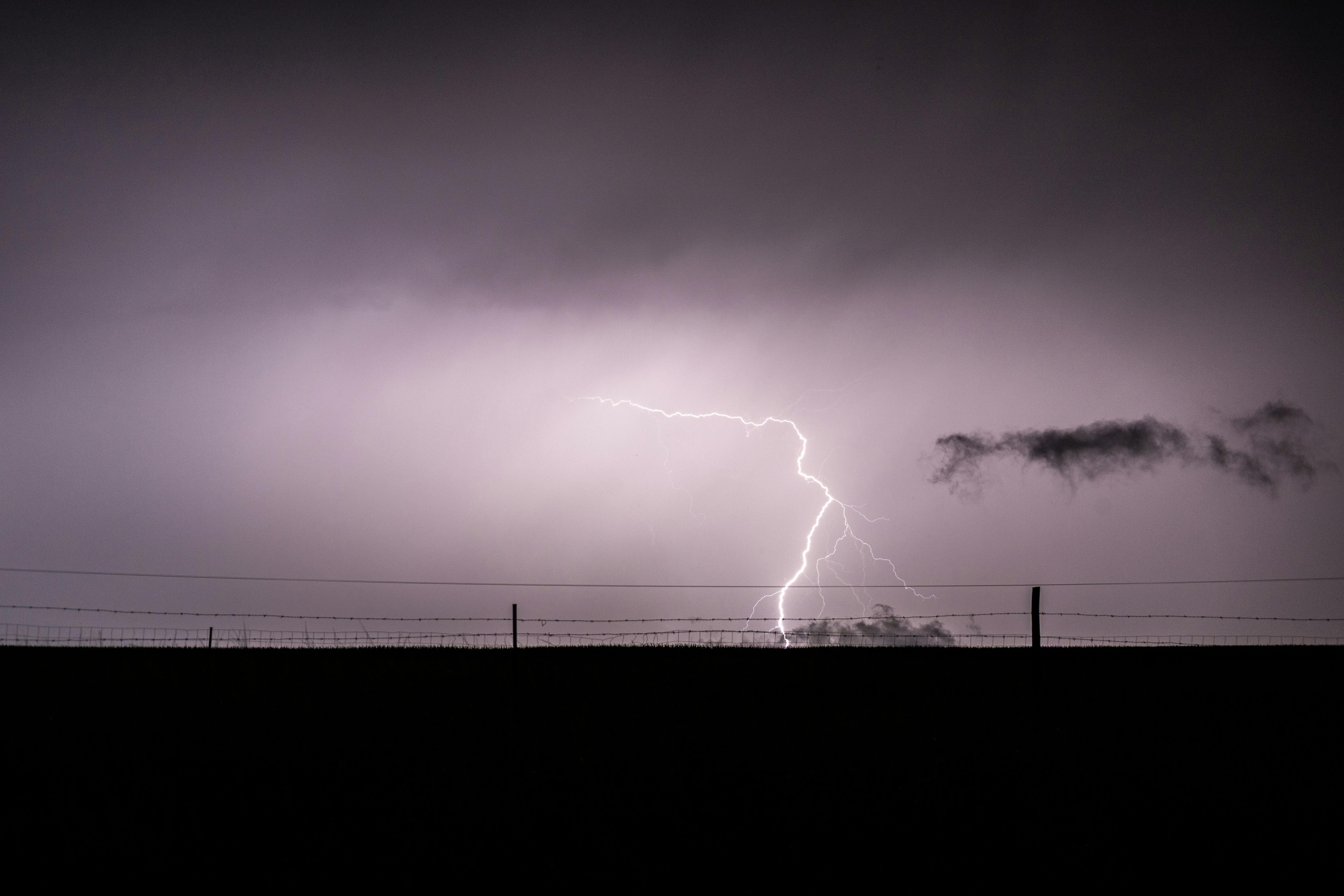 Thunderstorm with glimmering lightnings over ocean · Free Stock Photo