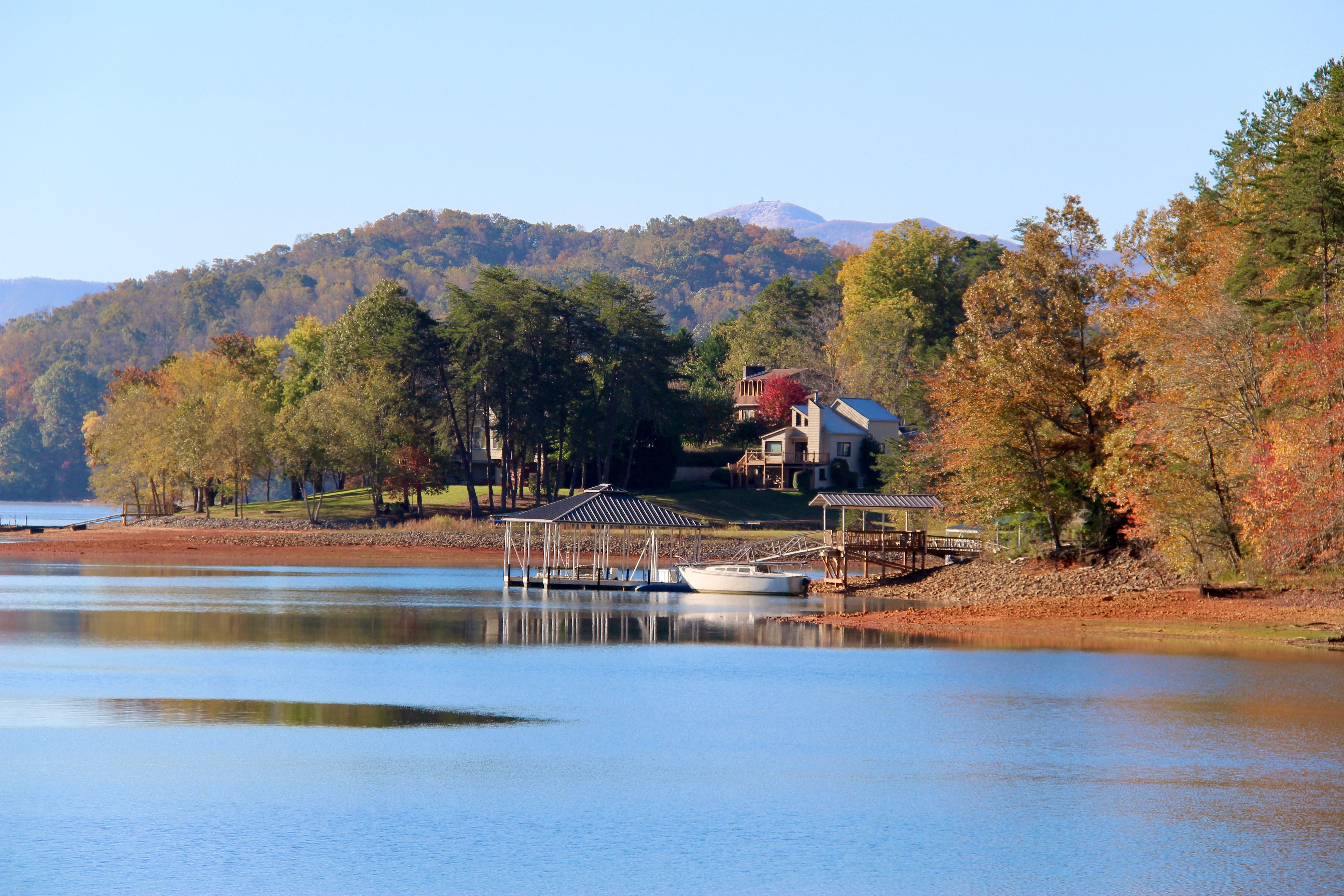 Tranquil Lakeside View with Autumn Trees and Boat · Free Stock Photo