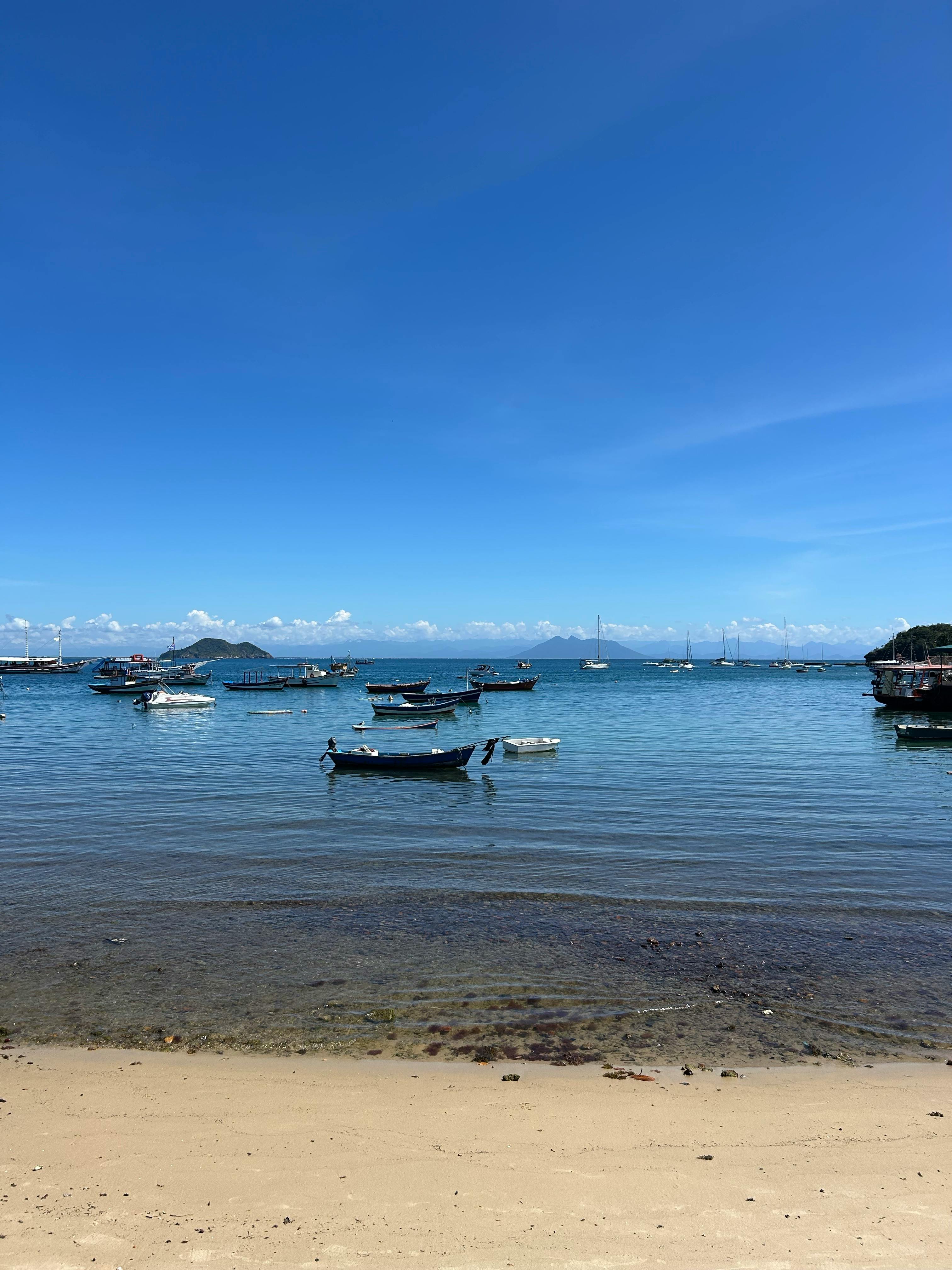 Perahu Di Perairan Pantai Yang Tenang Di Bawah Langit Cerah · Foto Stok ...