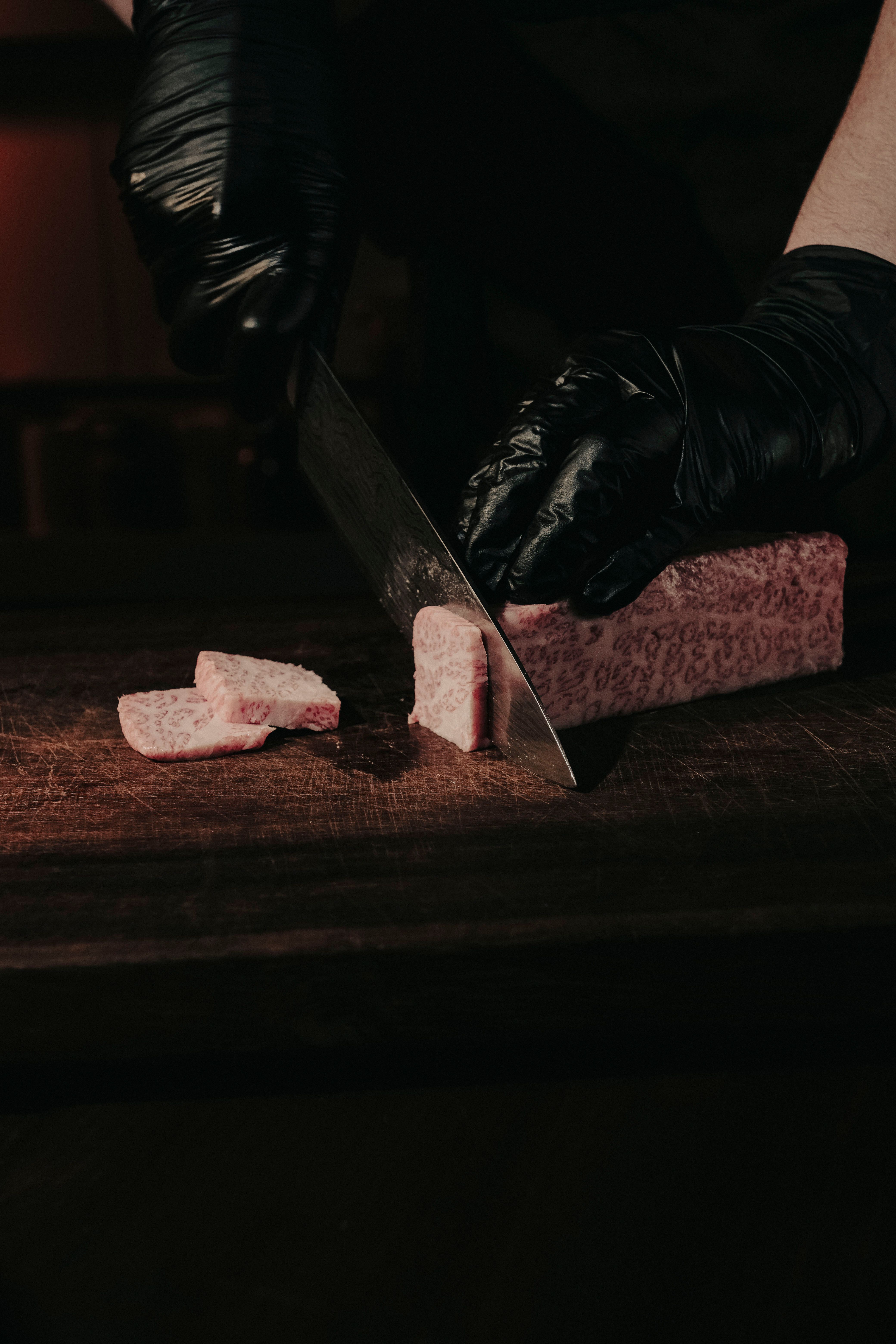 Cutting Wagyu Beef with Precision on a Dark Surface · Free Stock Photo