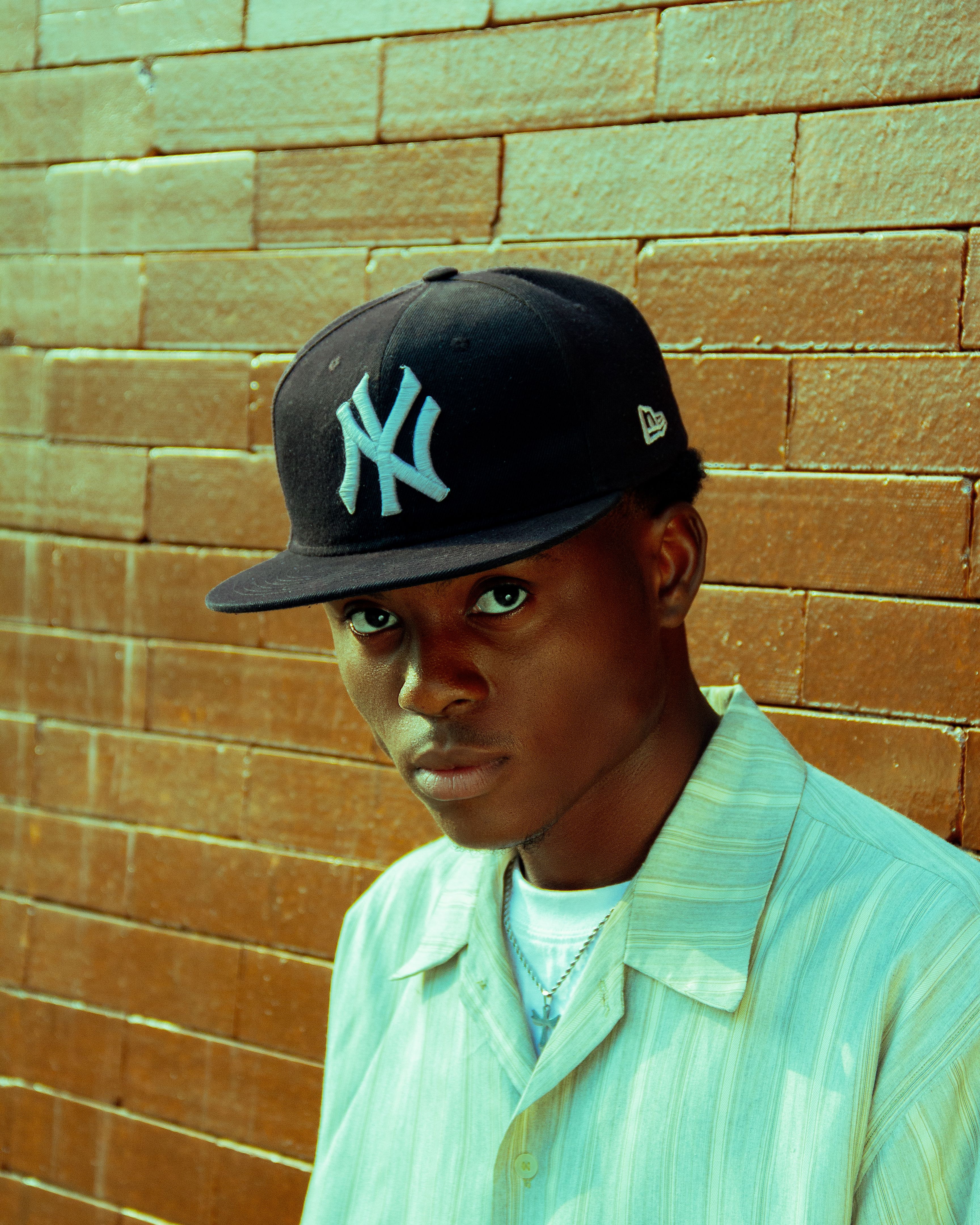 Young Man in Baseball Cap Posing Outdoors · Free Stock Photo