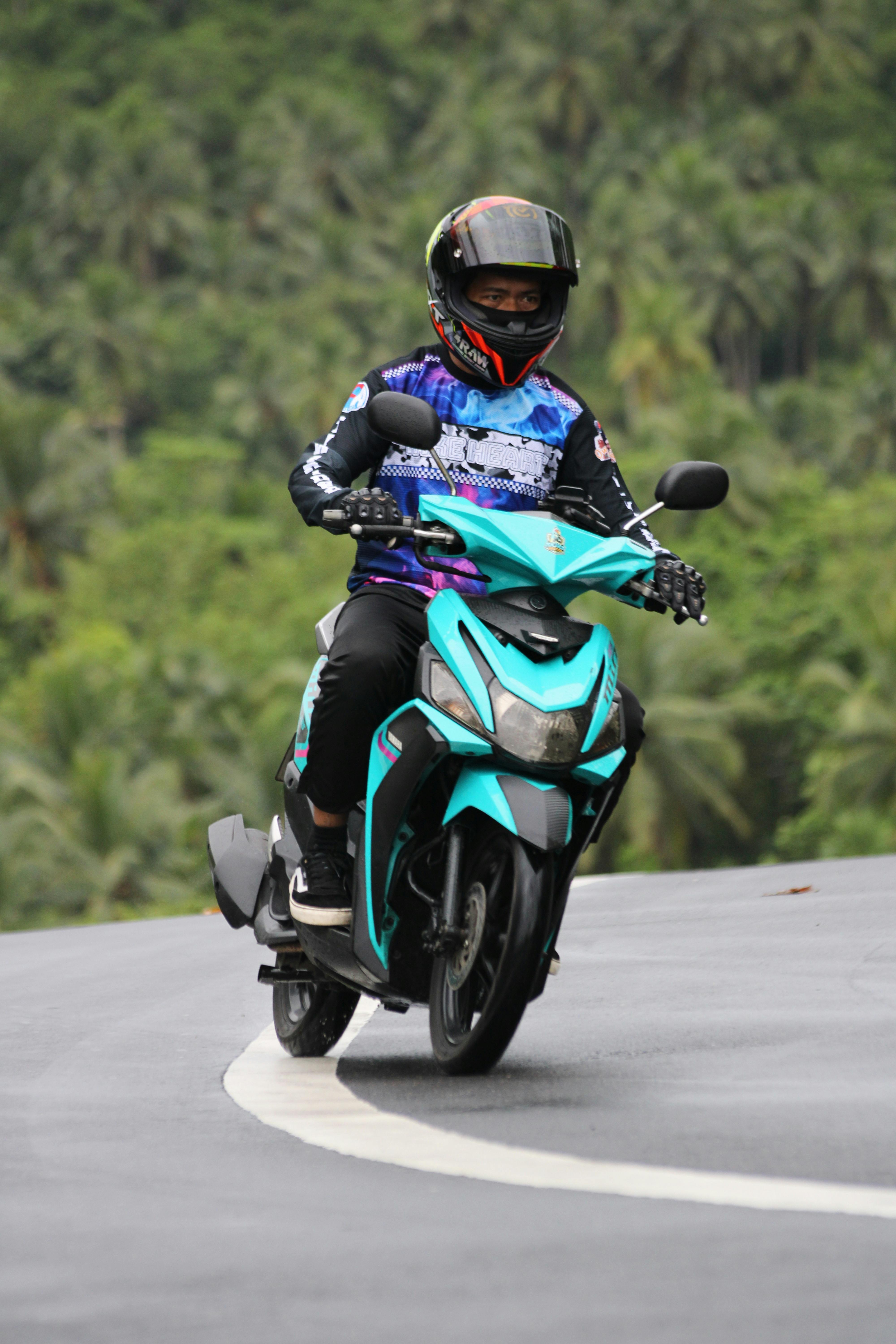 Person Riding Scooter on Curved Road Outdoors · Free Stock Photo