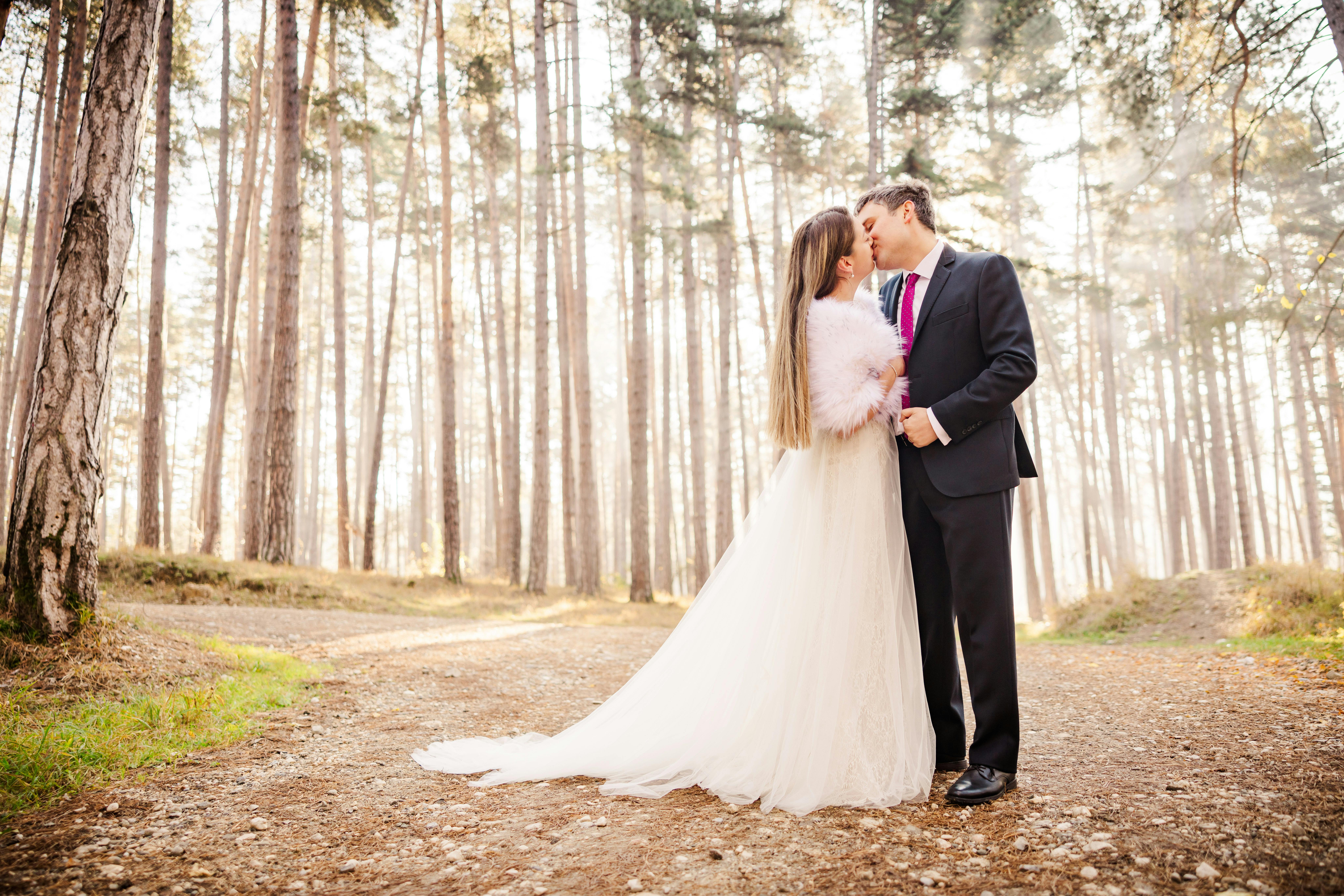 Romantic Wedding Kiss in a Serene Forest Setting · Free Stock Photo