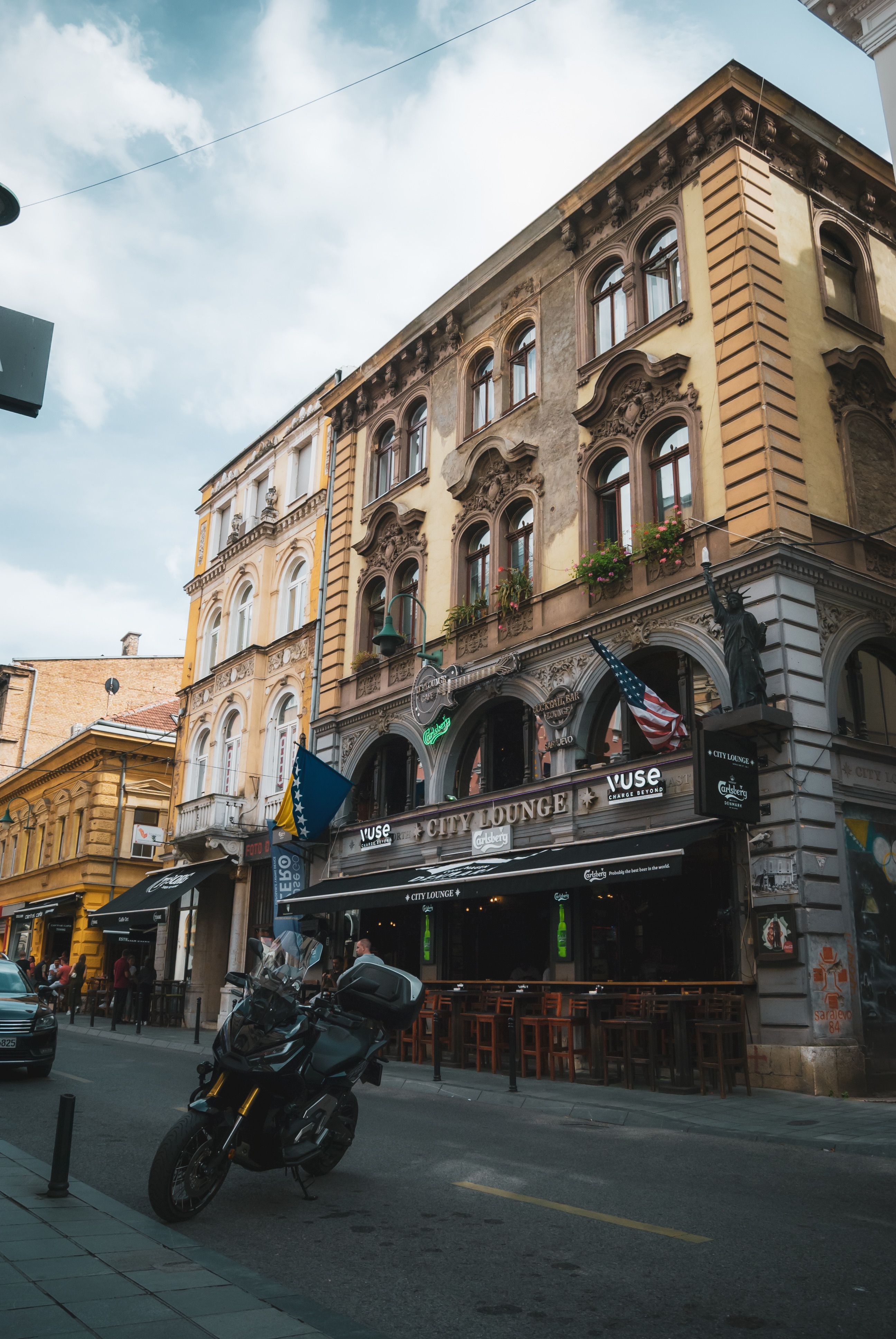 Historic European City Street with Cafe and Motorcycle · Free Stock Photo