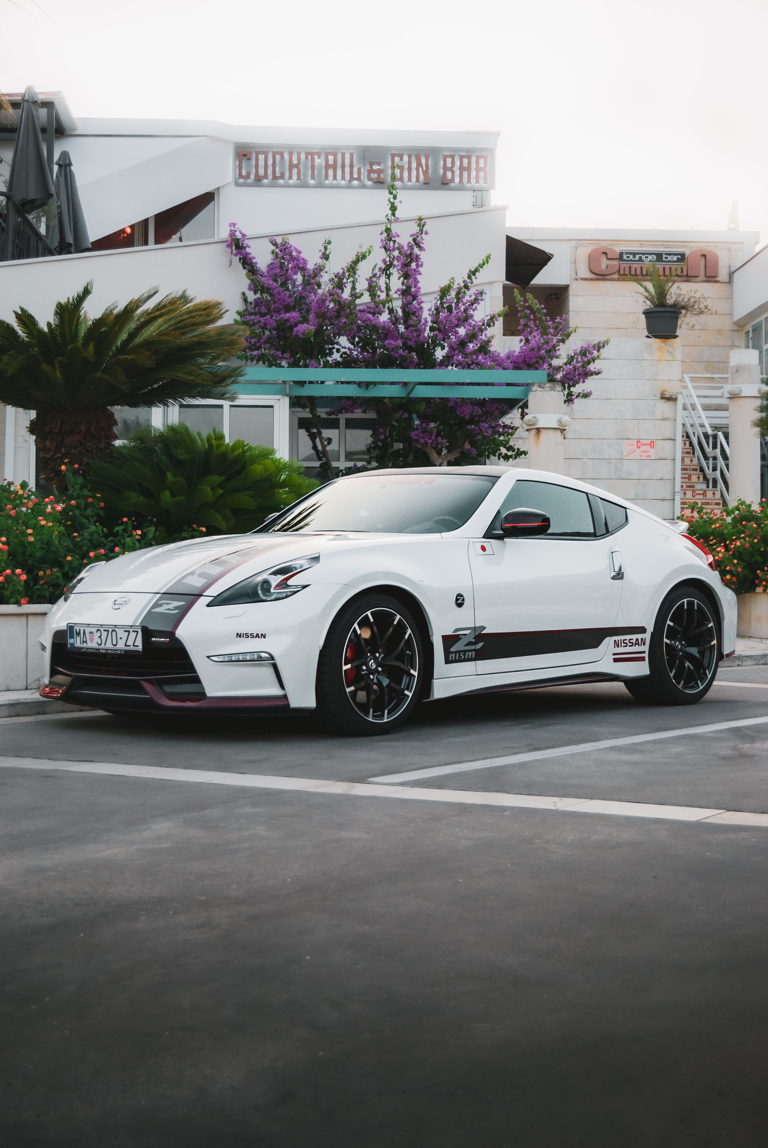 White Sports Car Parked by Gin Bar · Free Stock Photo