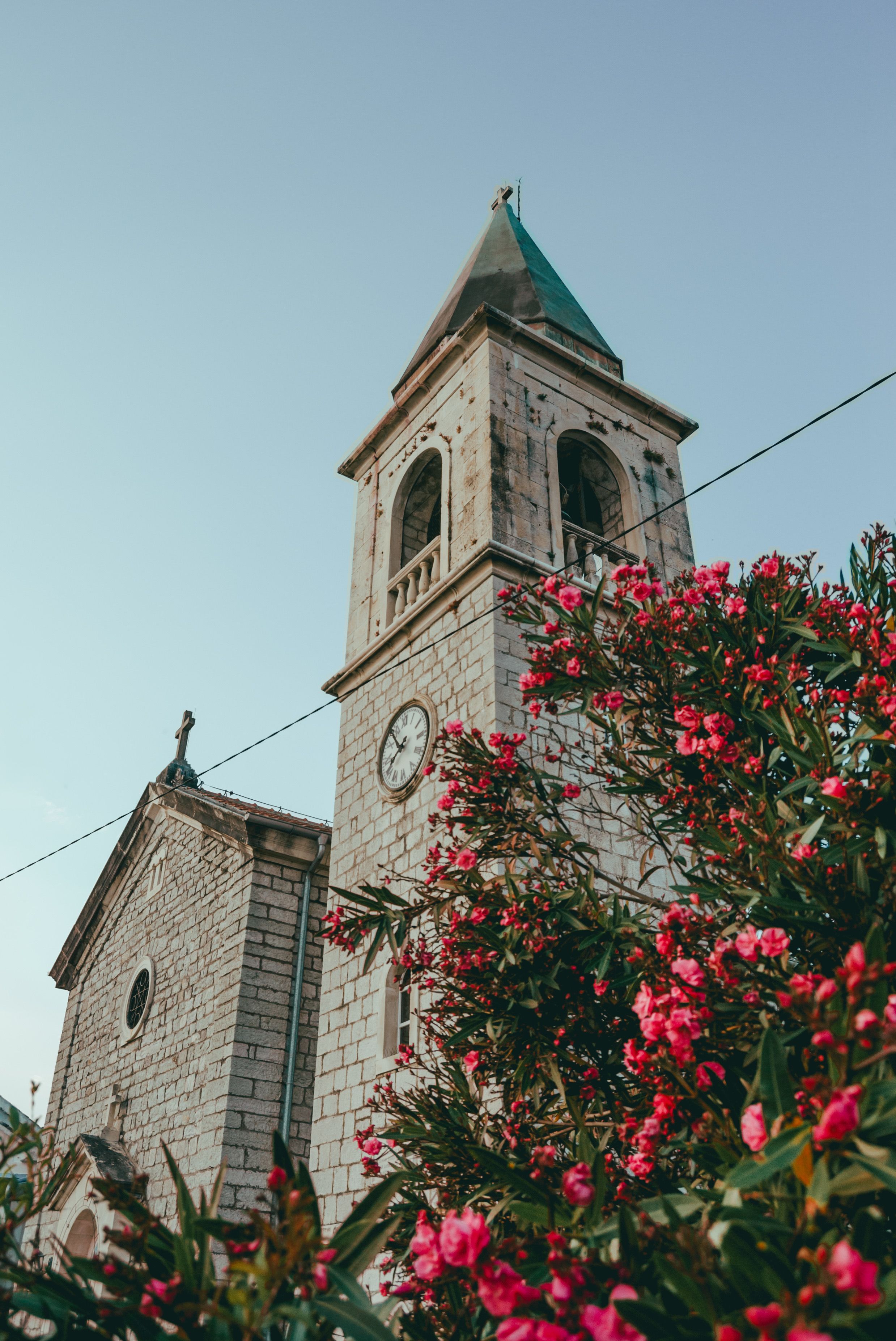 Charming Stone Church Tower with Flowers · Free Stock Photo