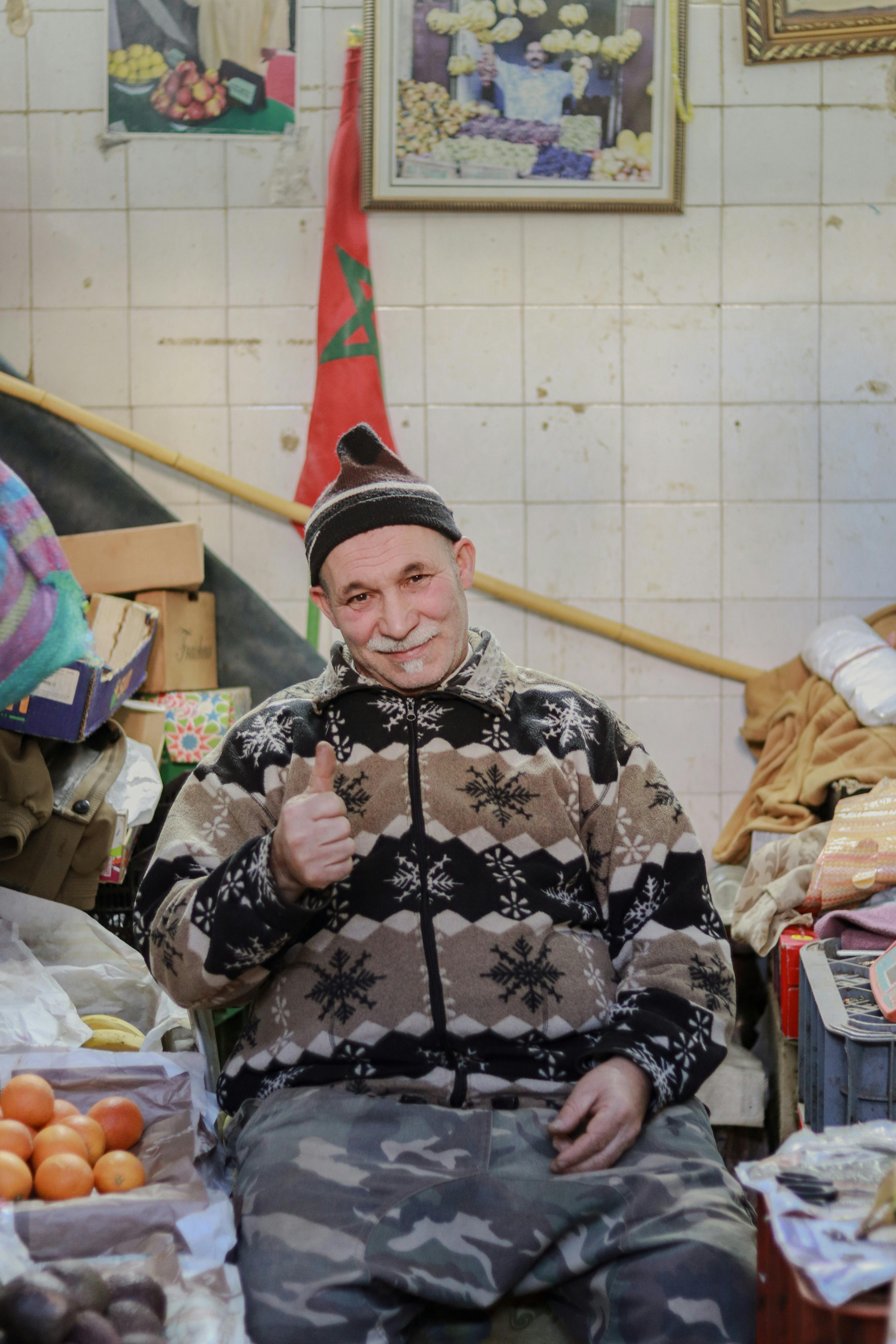 Smiling Shopkeeper Giving Thumbs Up in Market · Free Stock Photo